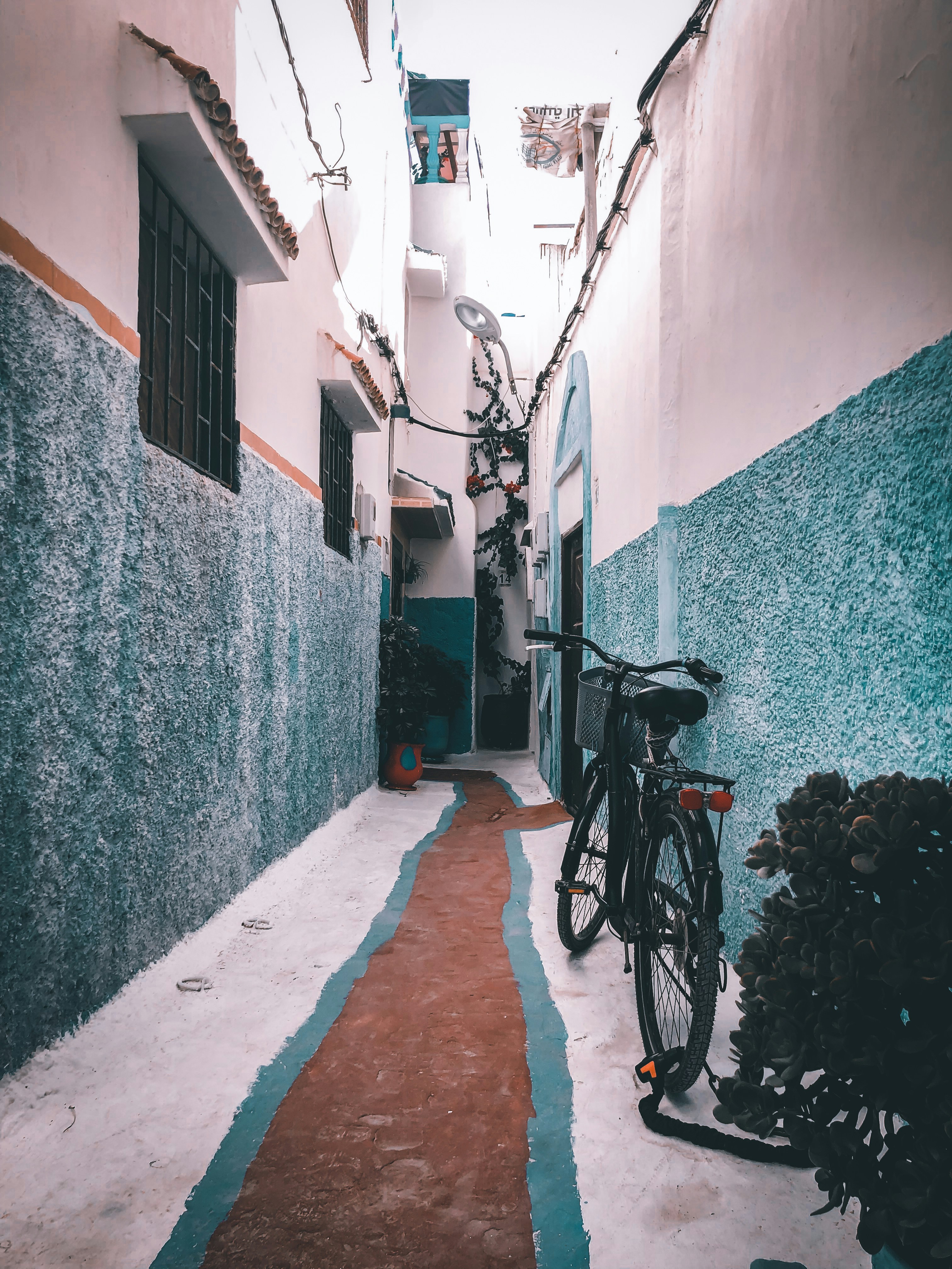 Rosy Light in a Narrow Blue-Walled Alley with a Bicycle