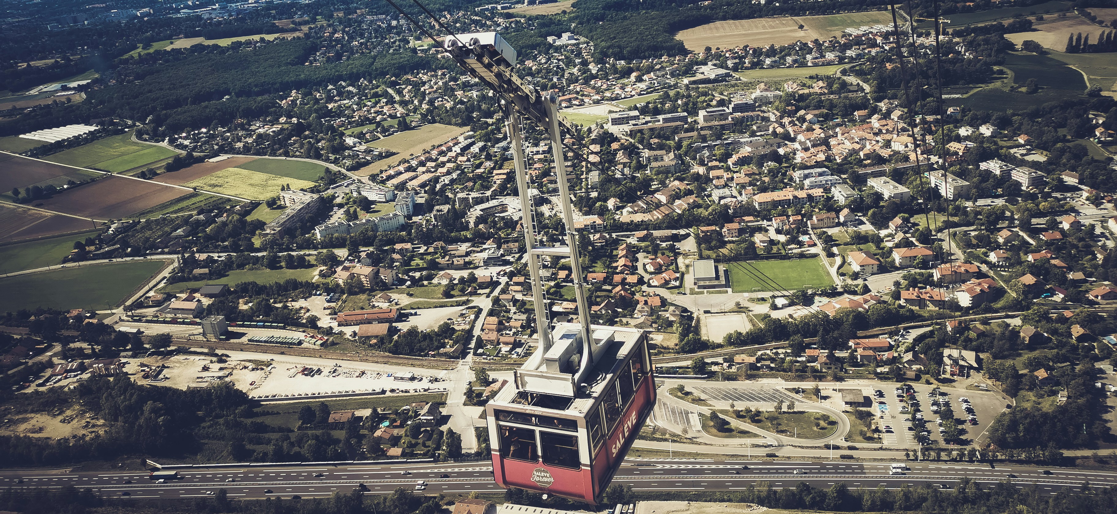 red and white cable car over city buildings during daytime