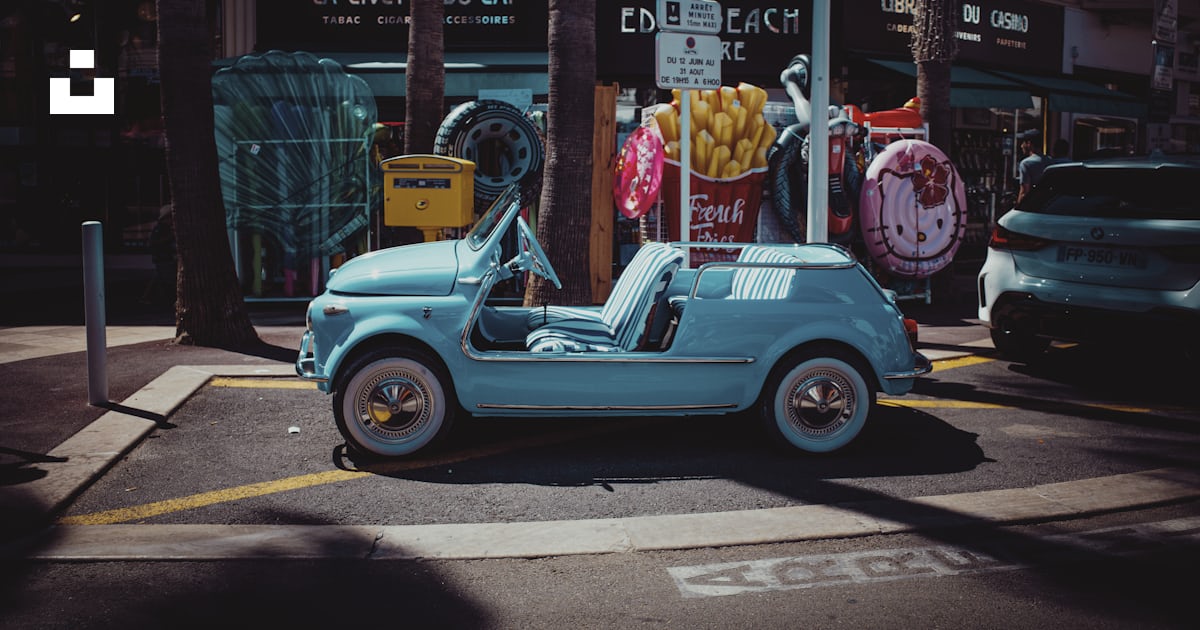 Blue And White Beetle Car Parked On Sidewalk During Daytime Photo