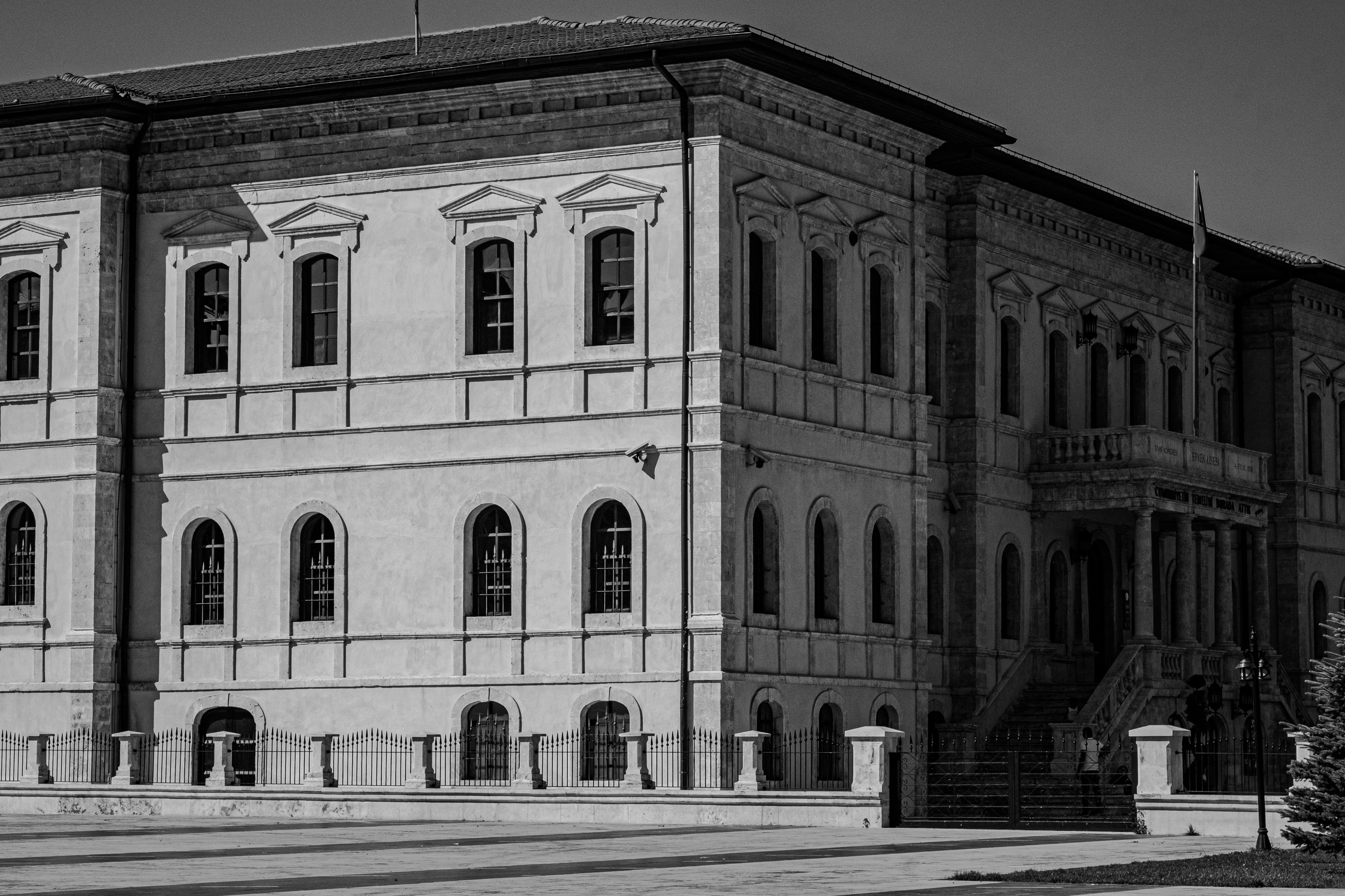 Black and white photograph of a historic building with arched windows and intricate architectural details.
