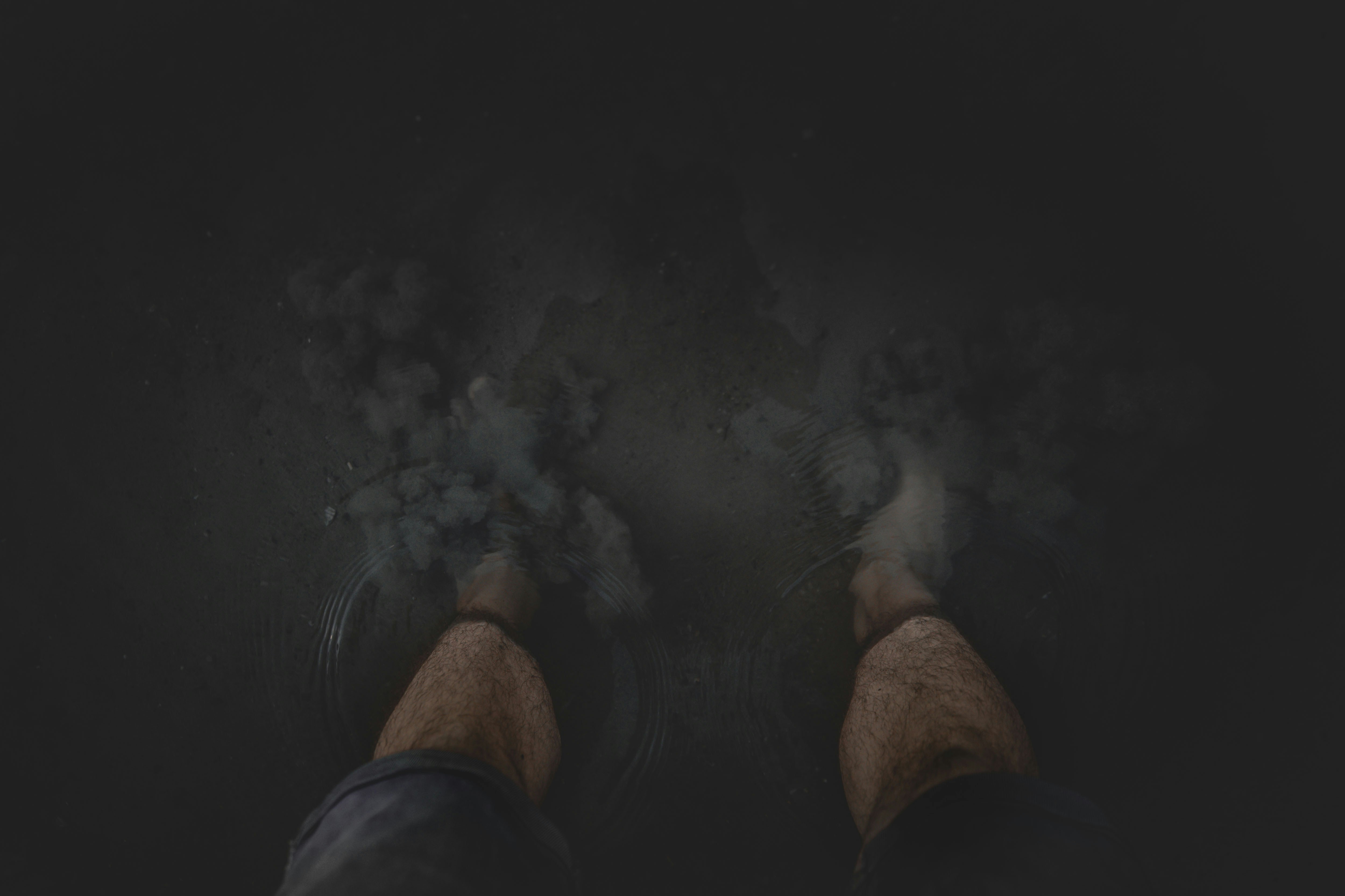 person in black shorts standing on black floor