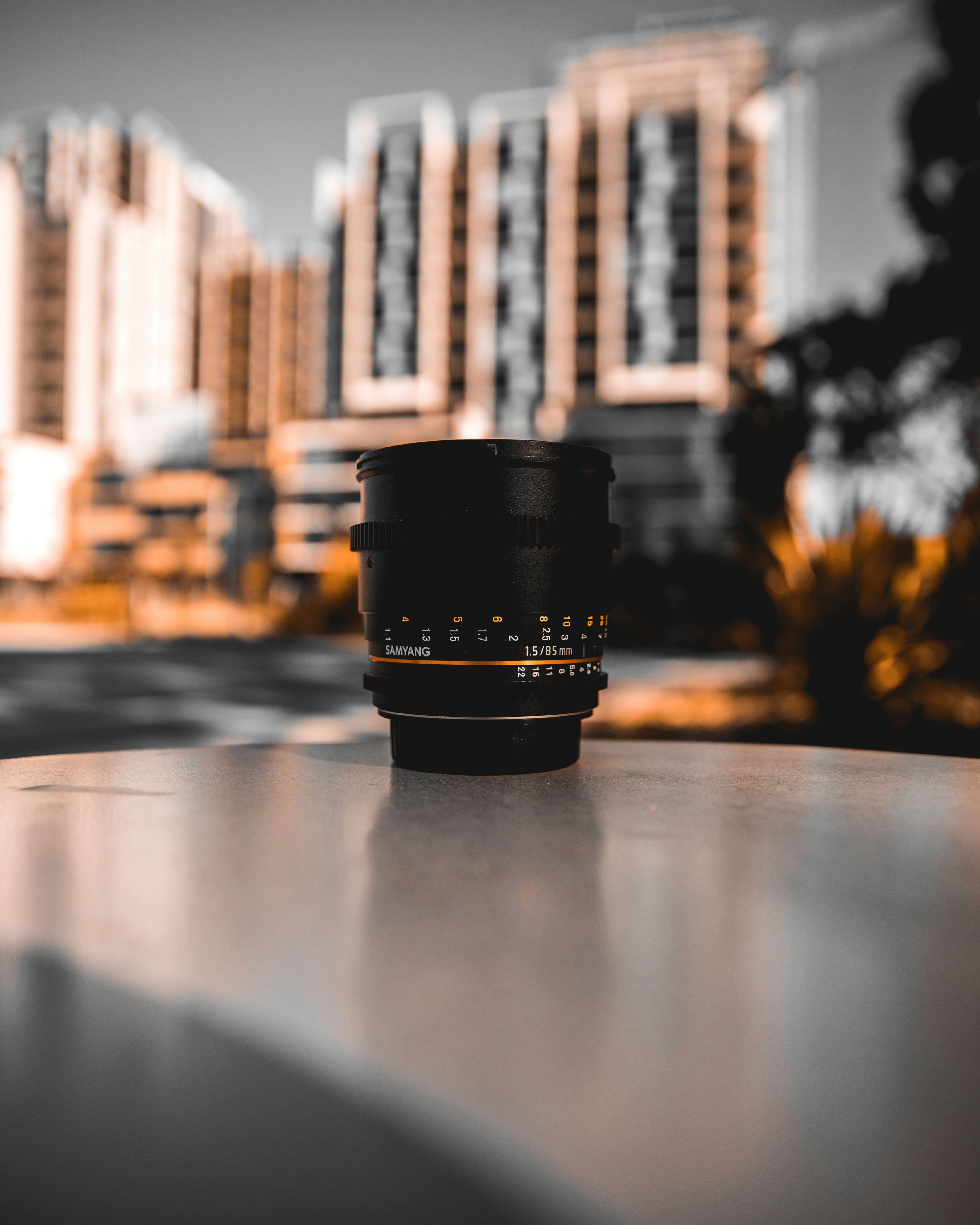 Macro Lens on a Stand: A lone prime lens anchors a blurred urban backdrop