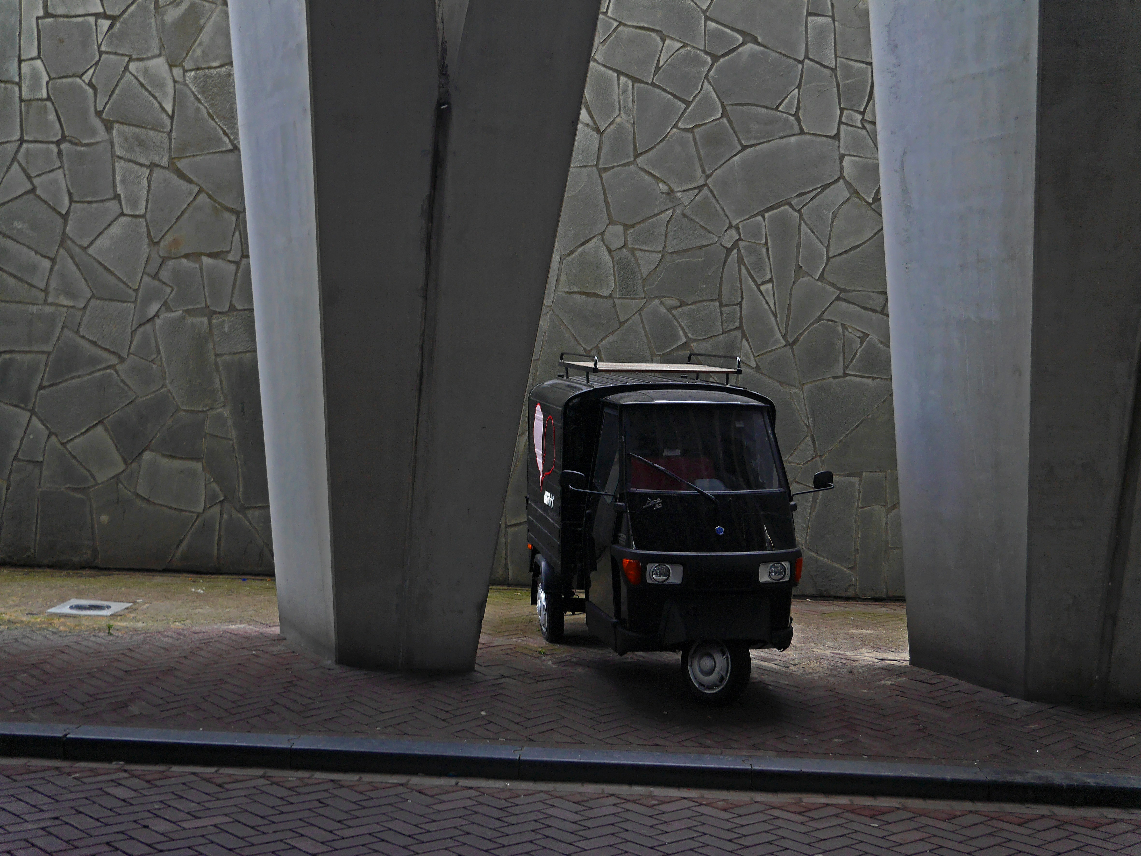 Under Concrete Arches: The Quiet Tuk-Tuk Under the Bridge