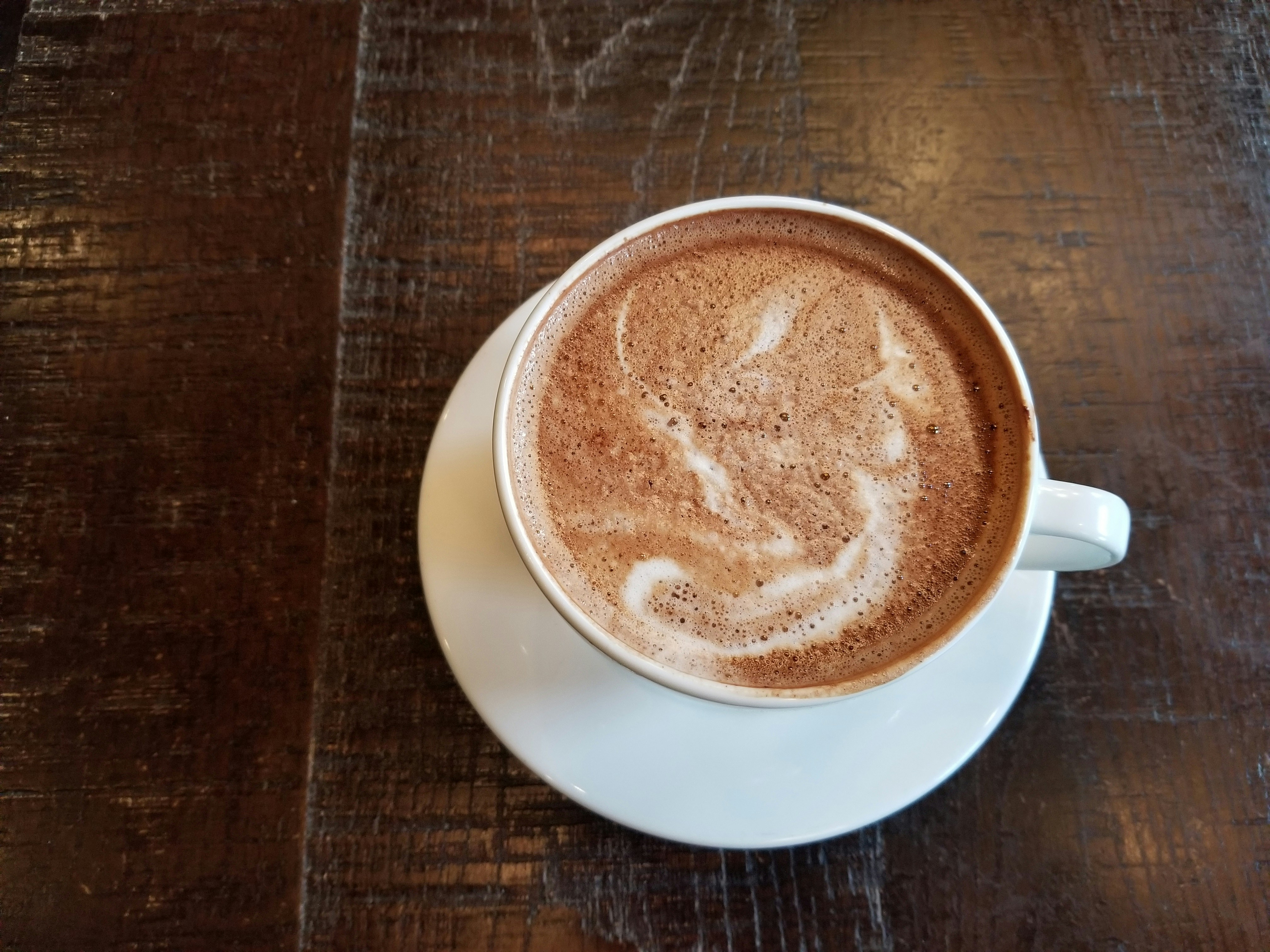 Latte Constellation: Cream Swirls on a Dark Wood Table