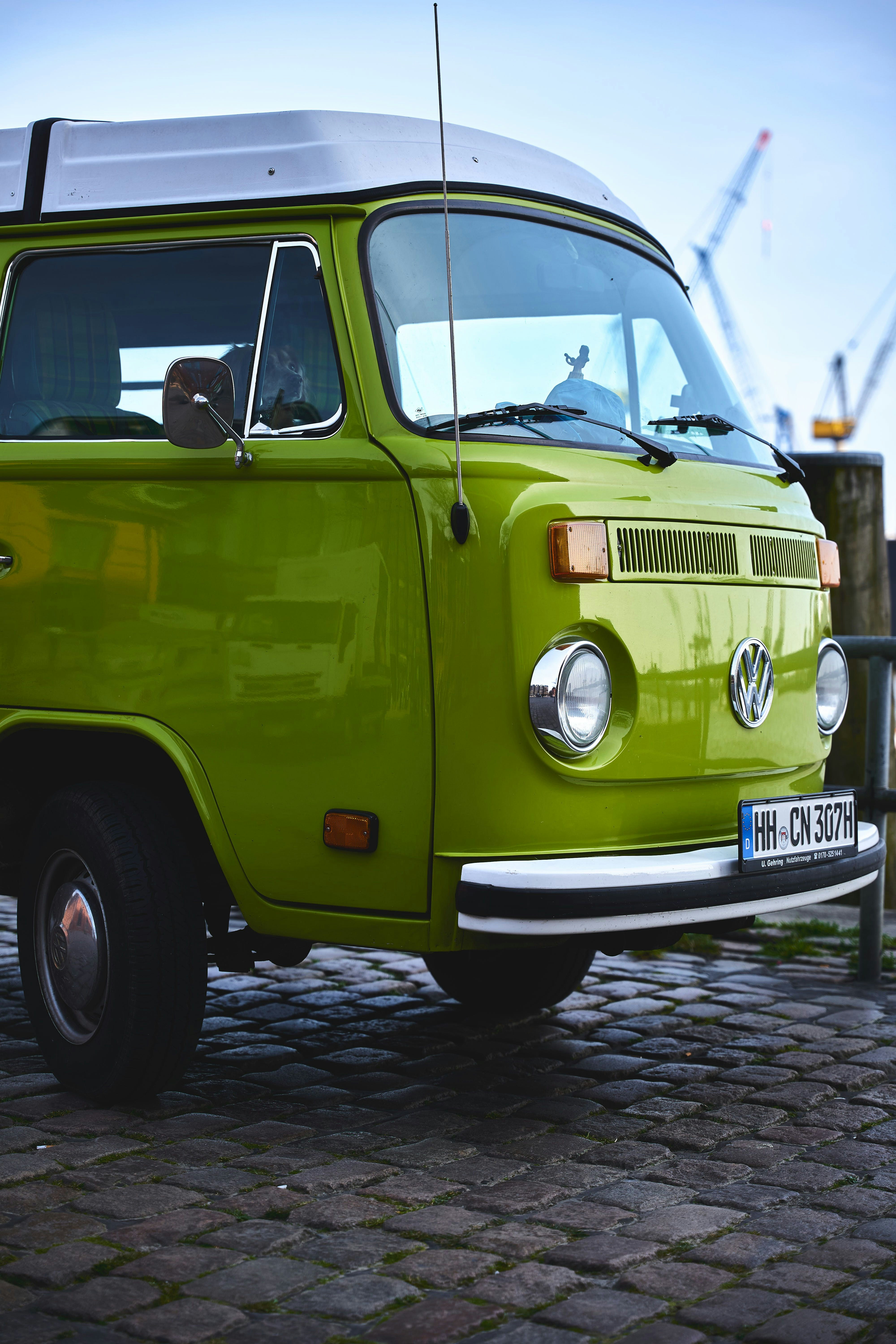A green van parked on a cobblestone street photo – Free Green Image on ...