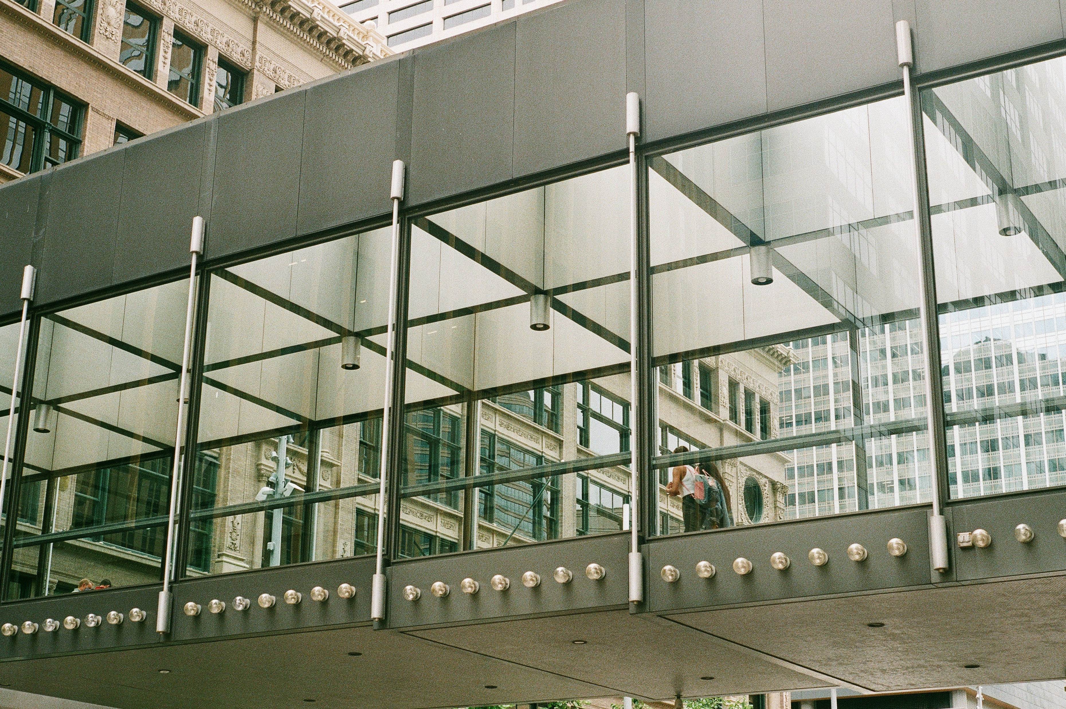 Modern glass walkway reflecting historic architecture, showcasing the blend of old and new in urban design.