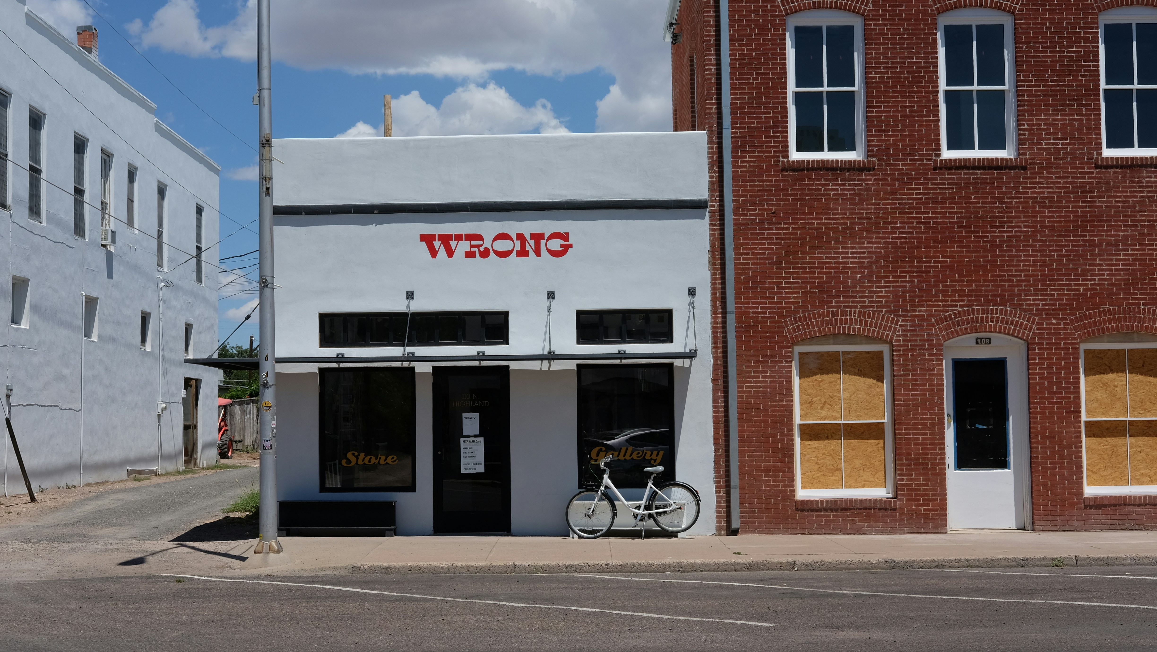 Storefront Duo: White Facade with Bicycle at Street Level