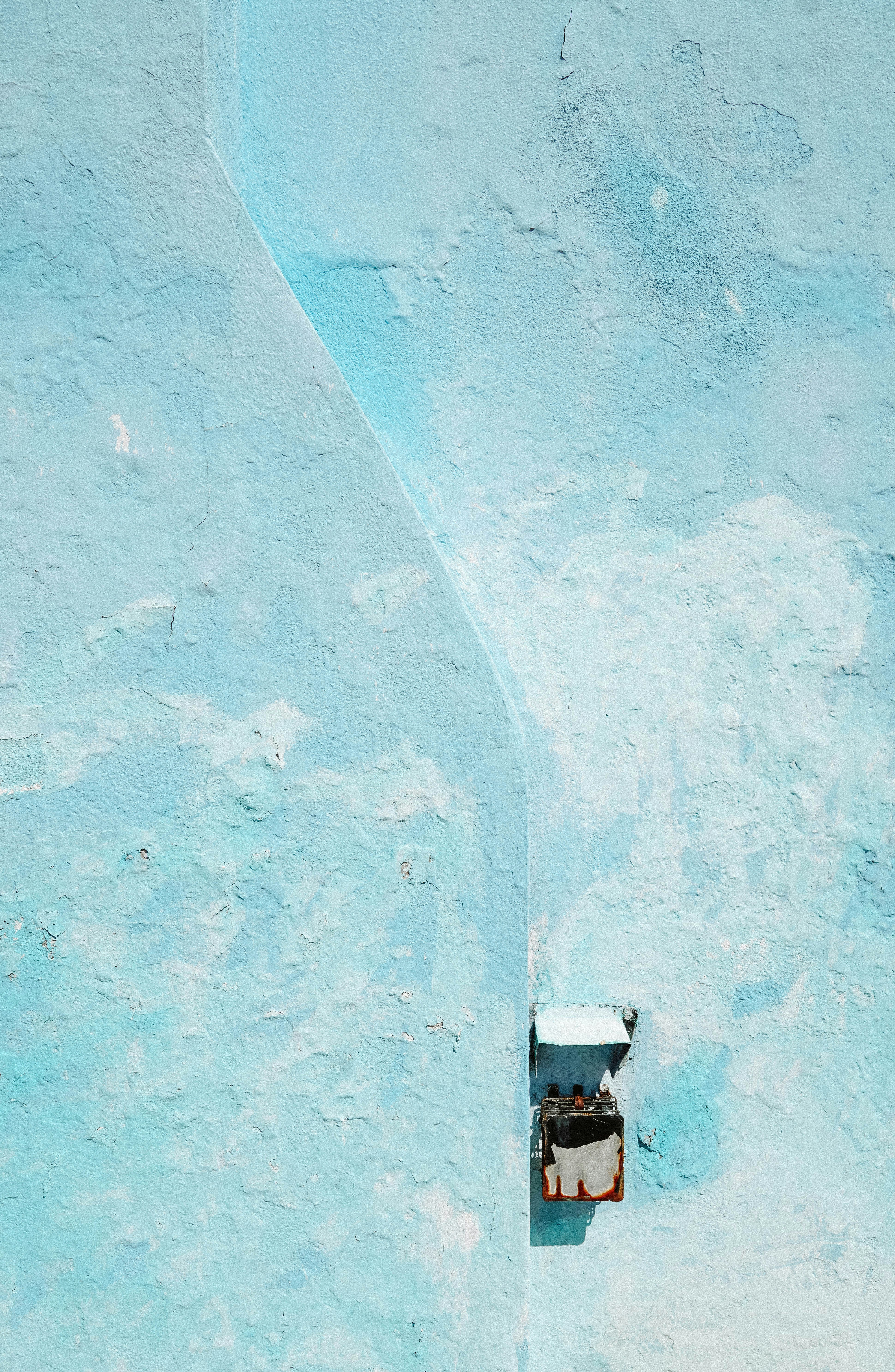 Turquoise Facade Curve with a Rusted Mailbox