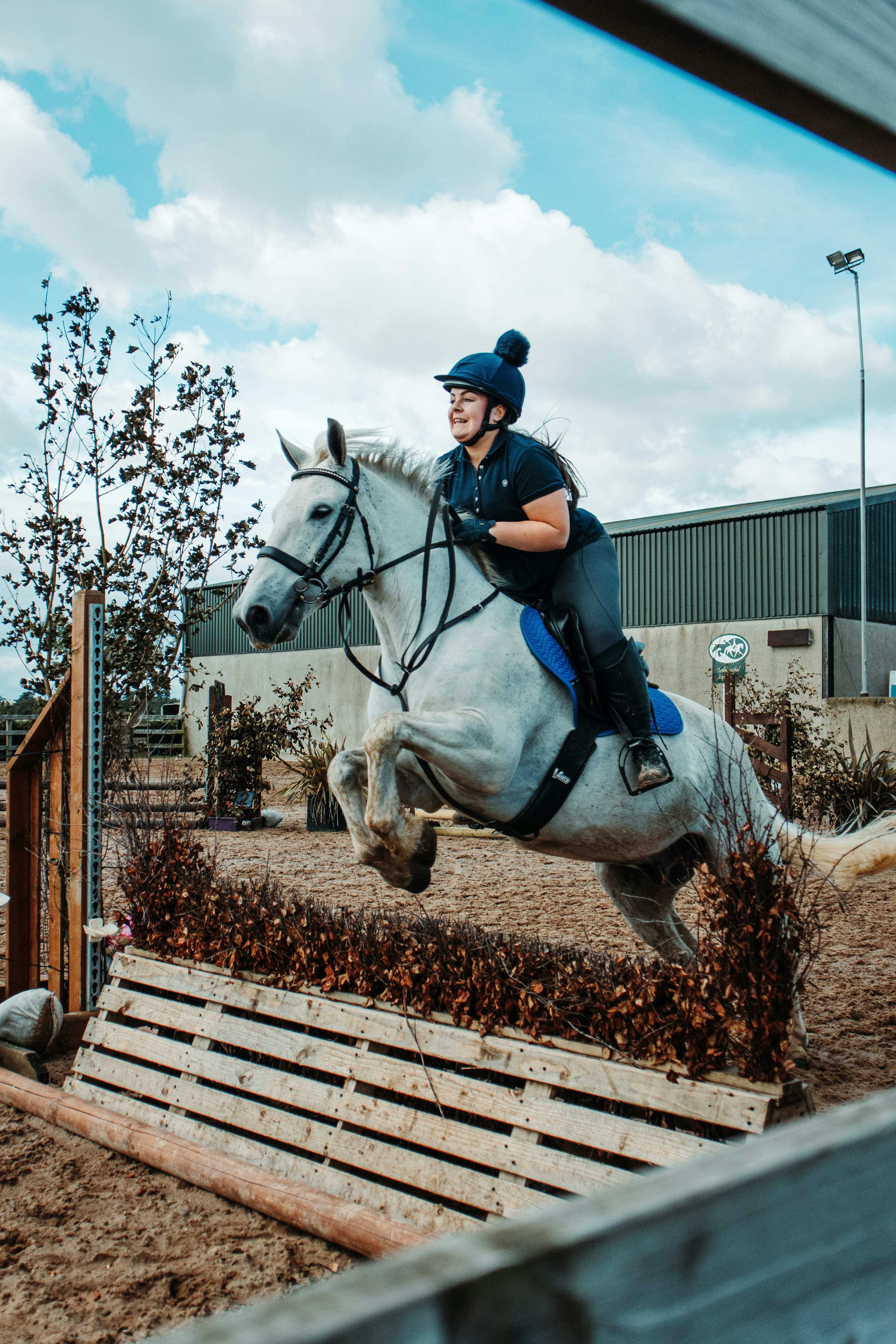 Leap of Focus: Young Rider and Grey Horse Clearing the Jump
