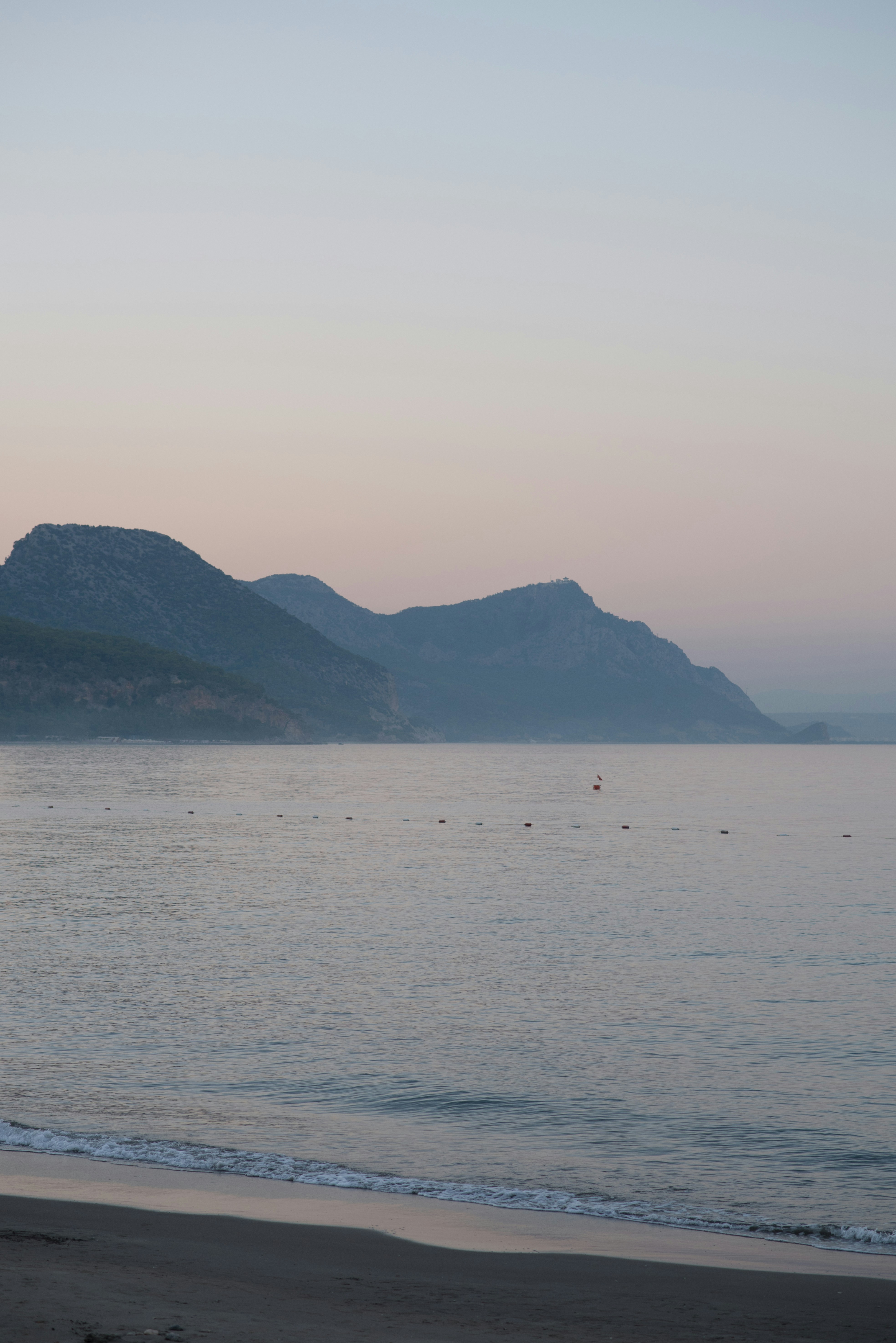 Dusk Over Quiet Bay: A Mountain Silhouette BeyondCalm Waves