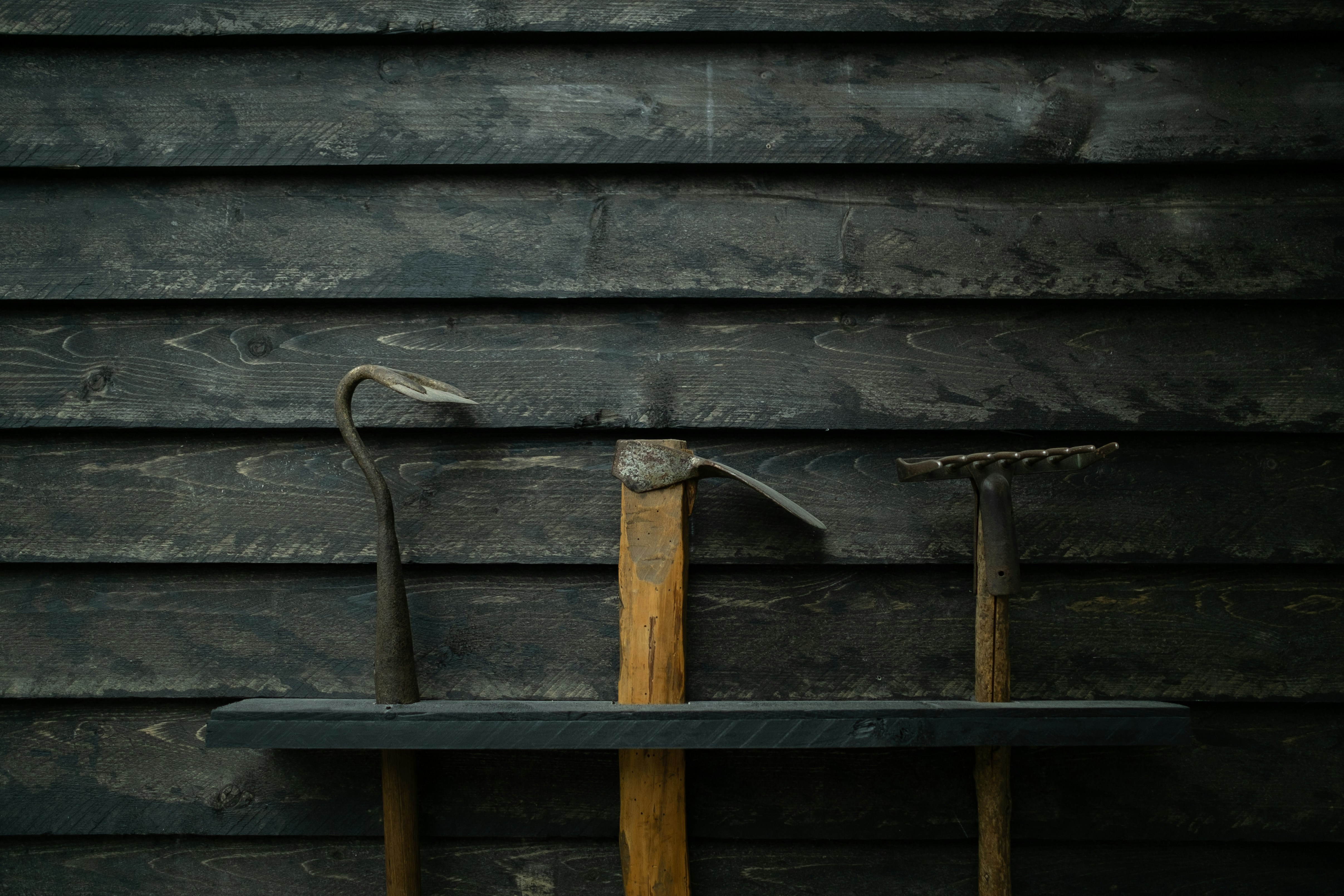 Centerline of Rust: A Trio of Weathered Tools on a Dark Wood Wall