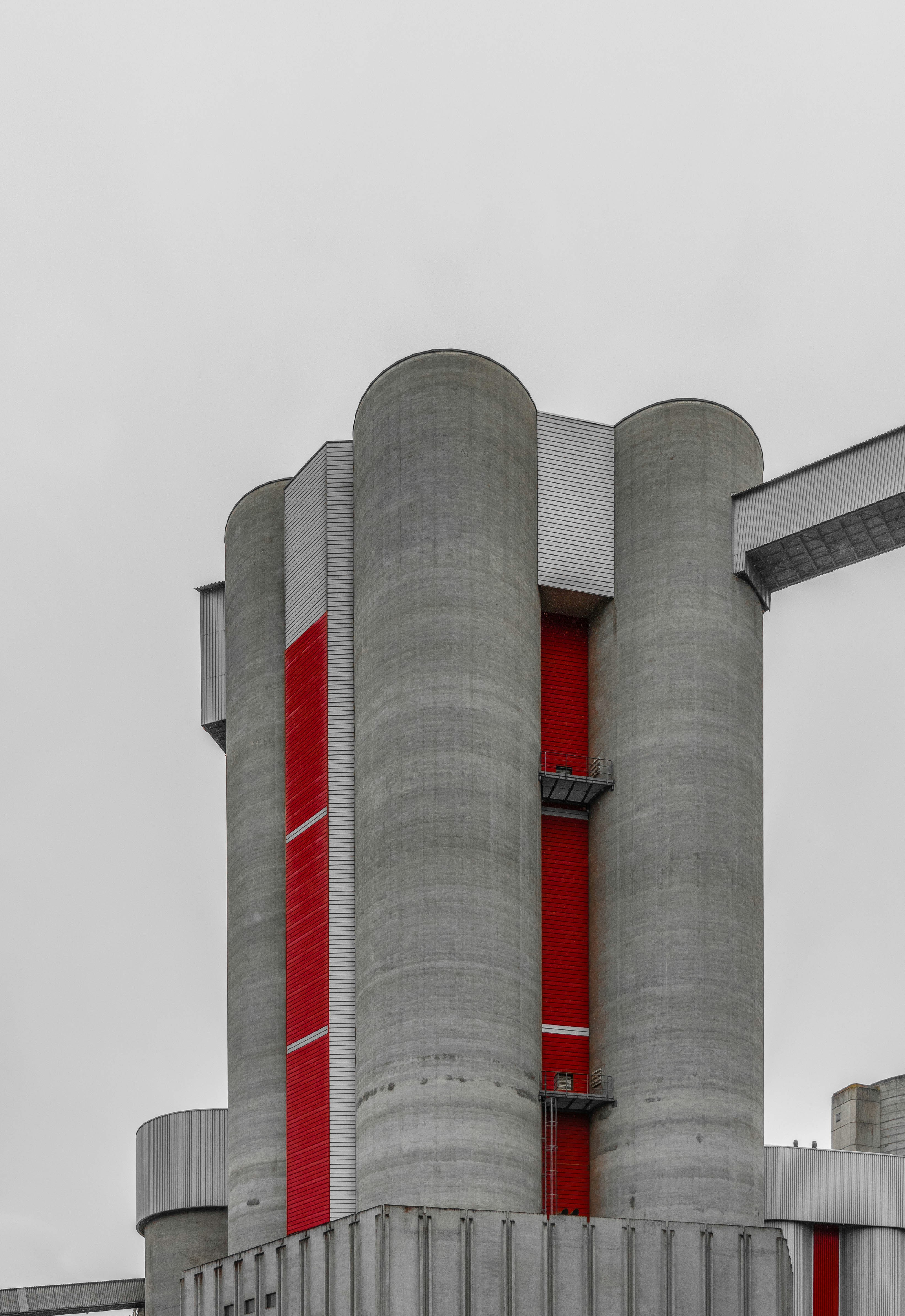 Red Stripes Between Monolithic Silos: Industrial Geometry in Gray