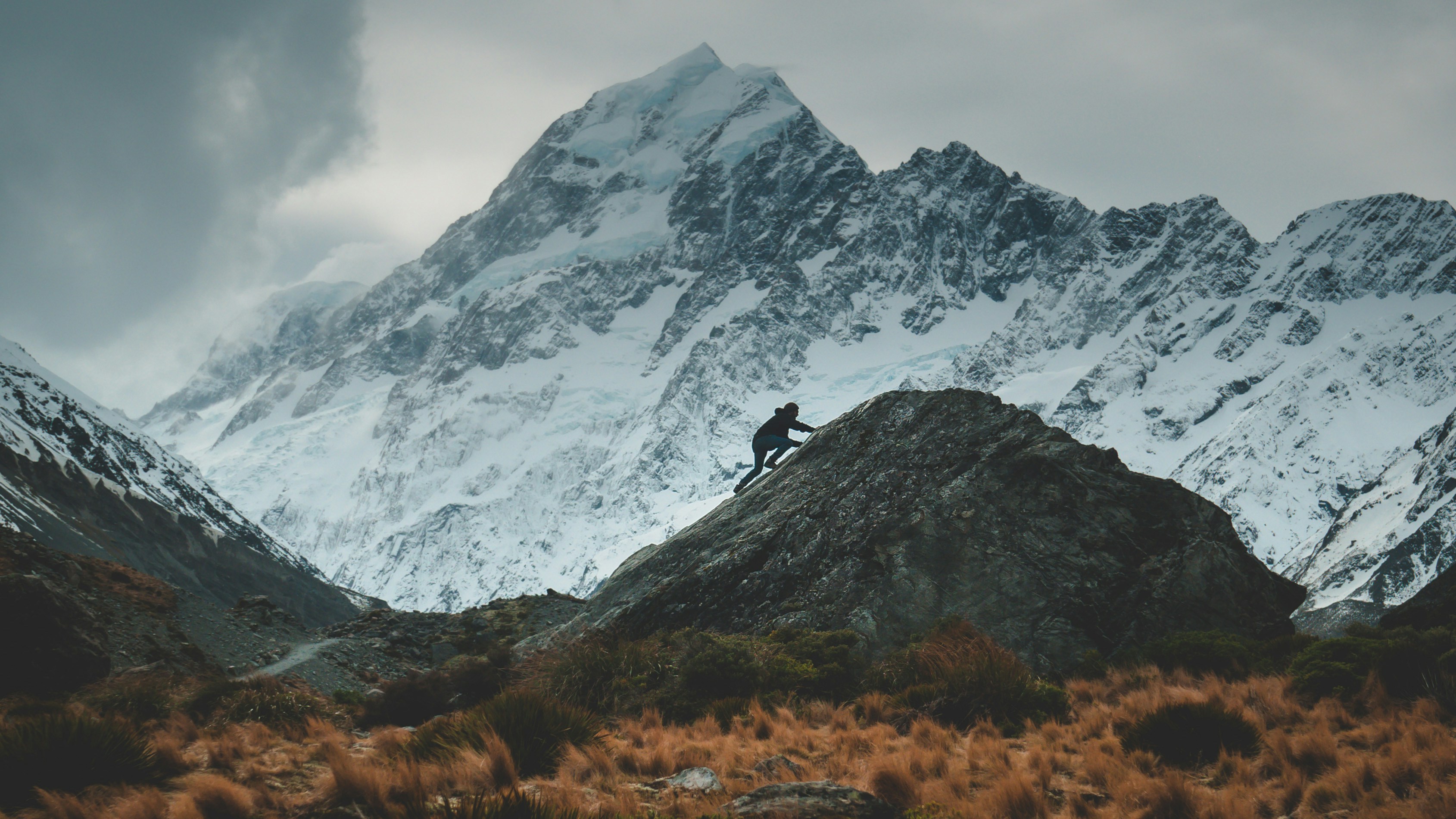 Lone Climber on a Granite Promontory Beneath Snowbound Giants