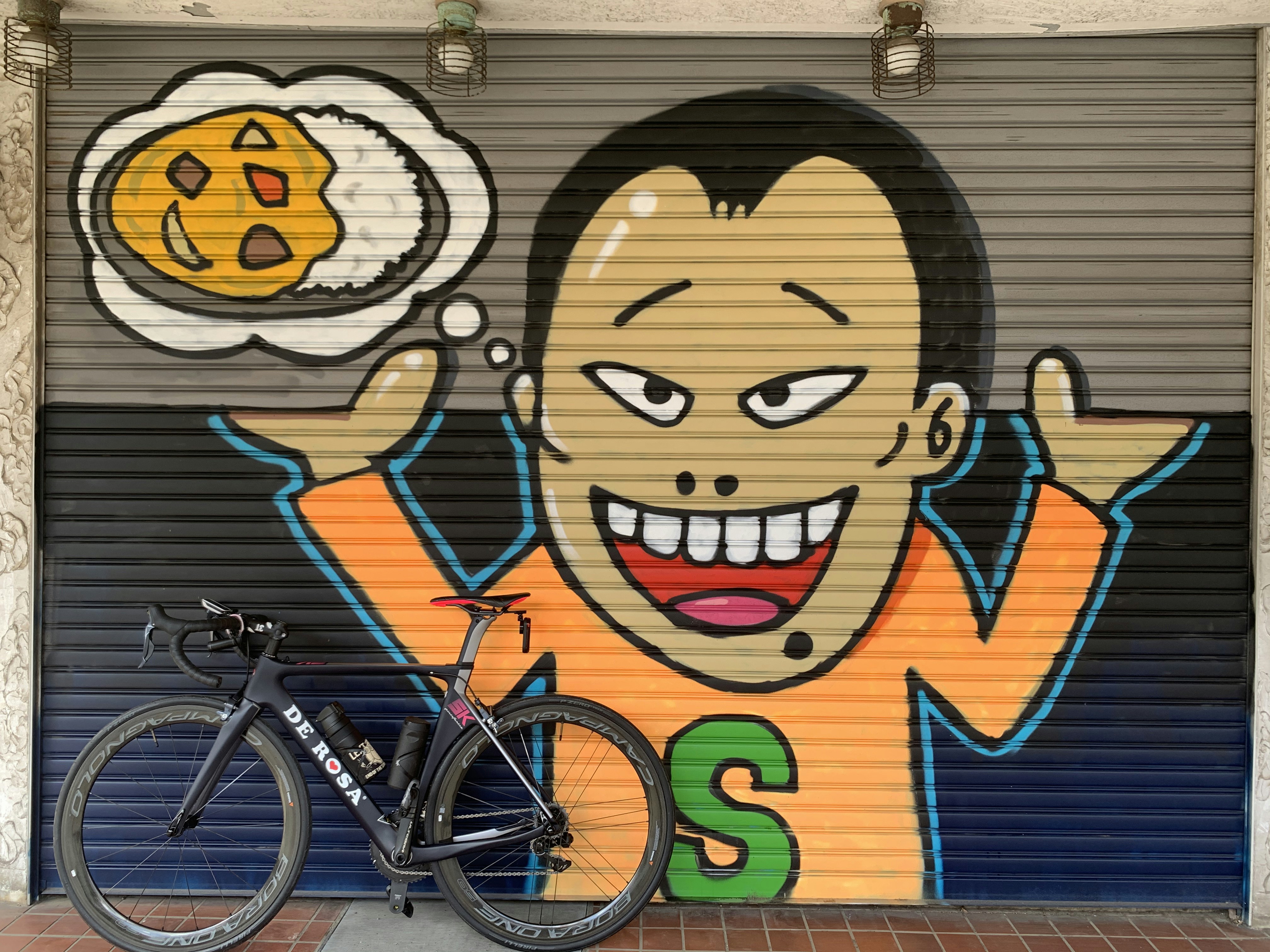 Cookie-Thought Grin: A Bicycle Beneath a Graffiti Mural