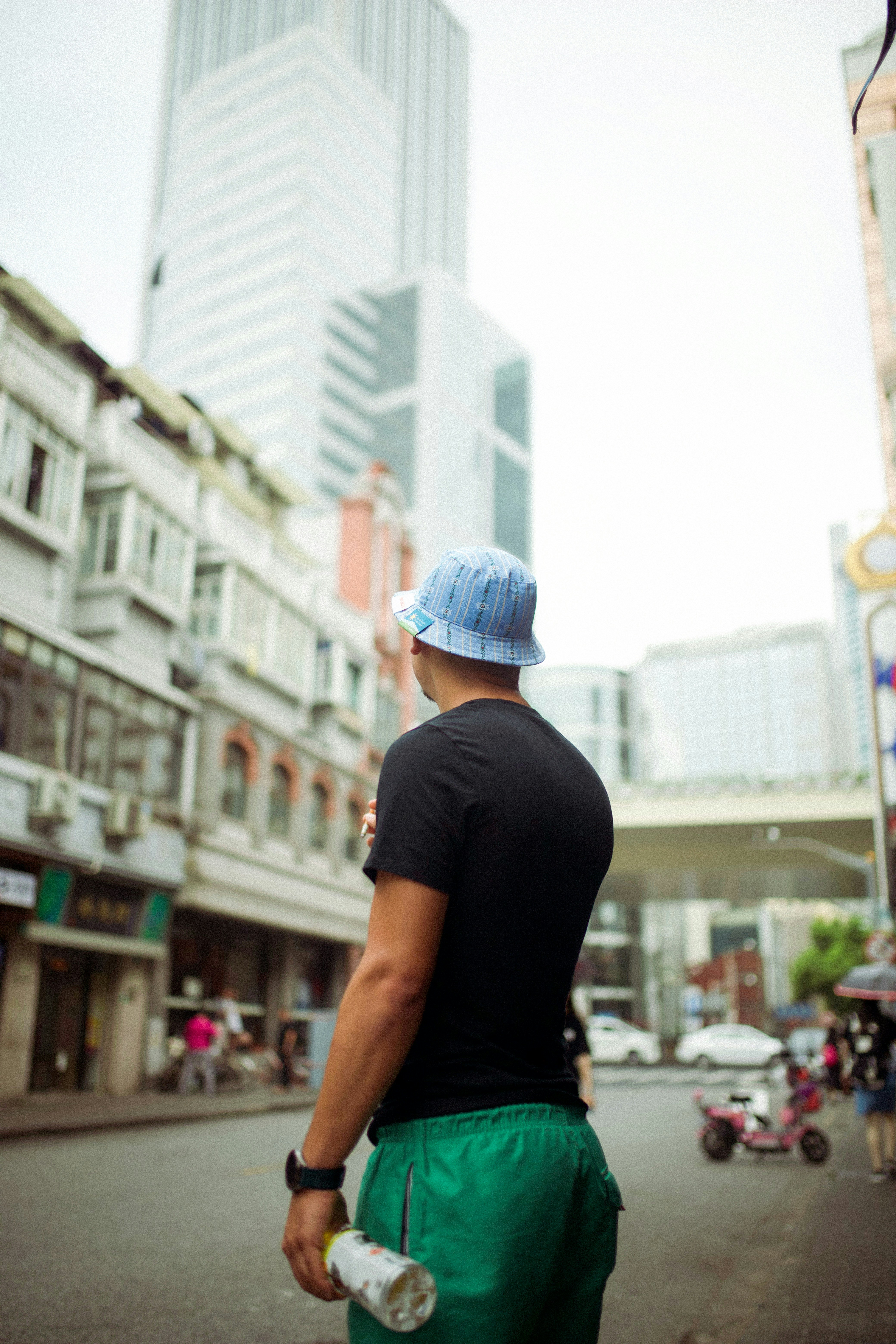 Urban Portrait: The Walker in a Blue Bucket Hat Amid City Echoes