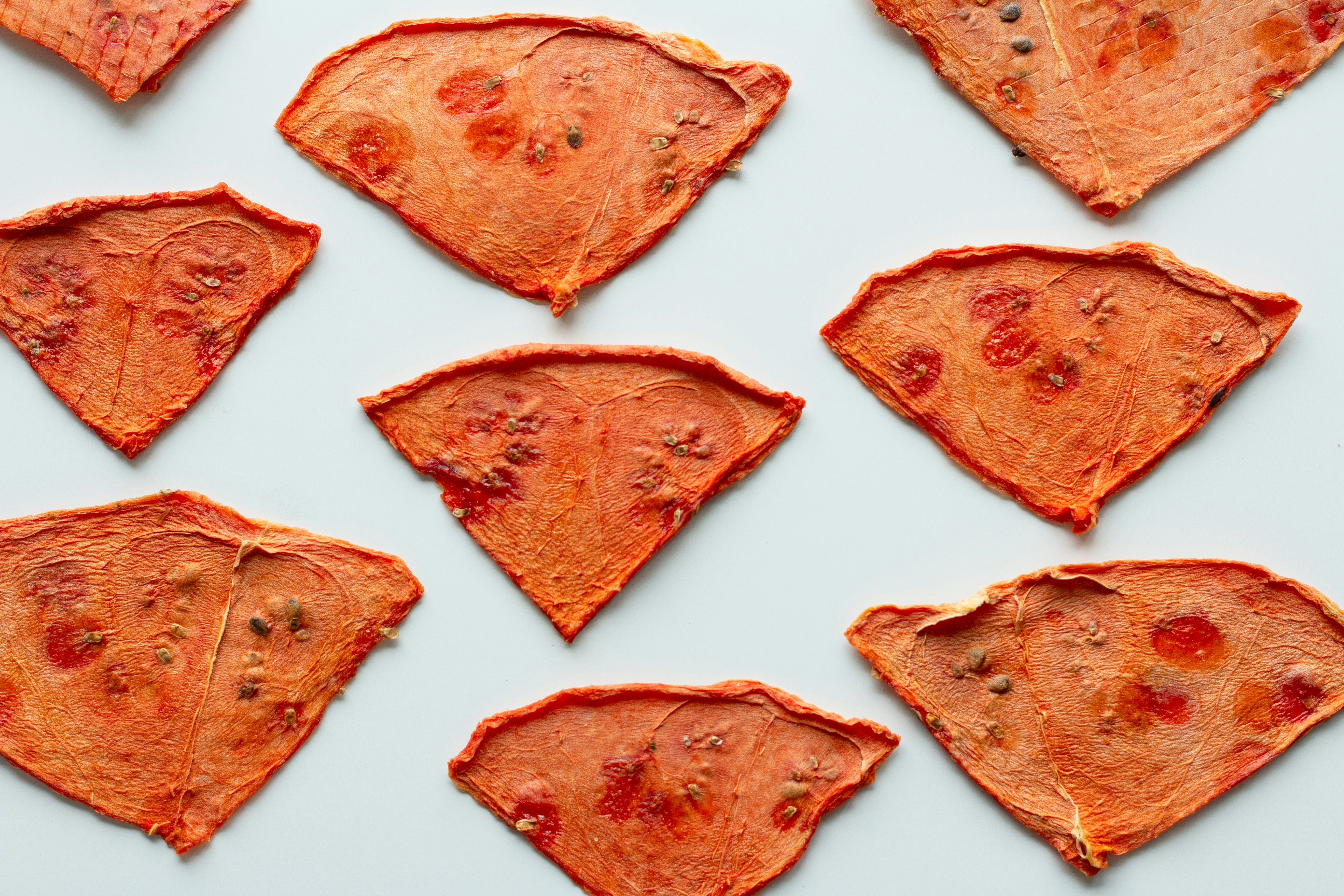 Triangular Paprika Chips Form a Soft Grid on Sky-Blue Surface