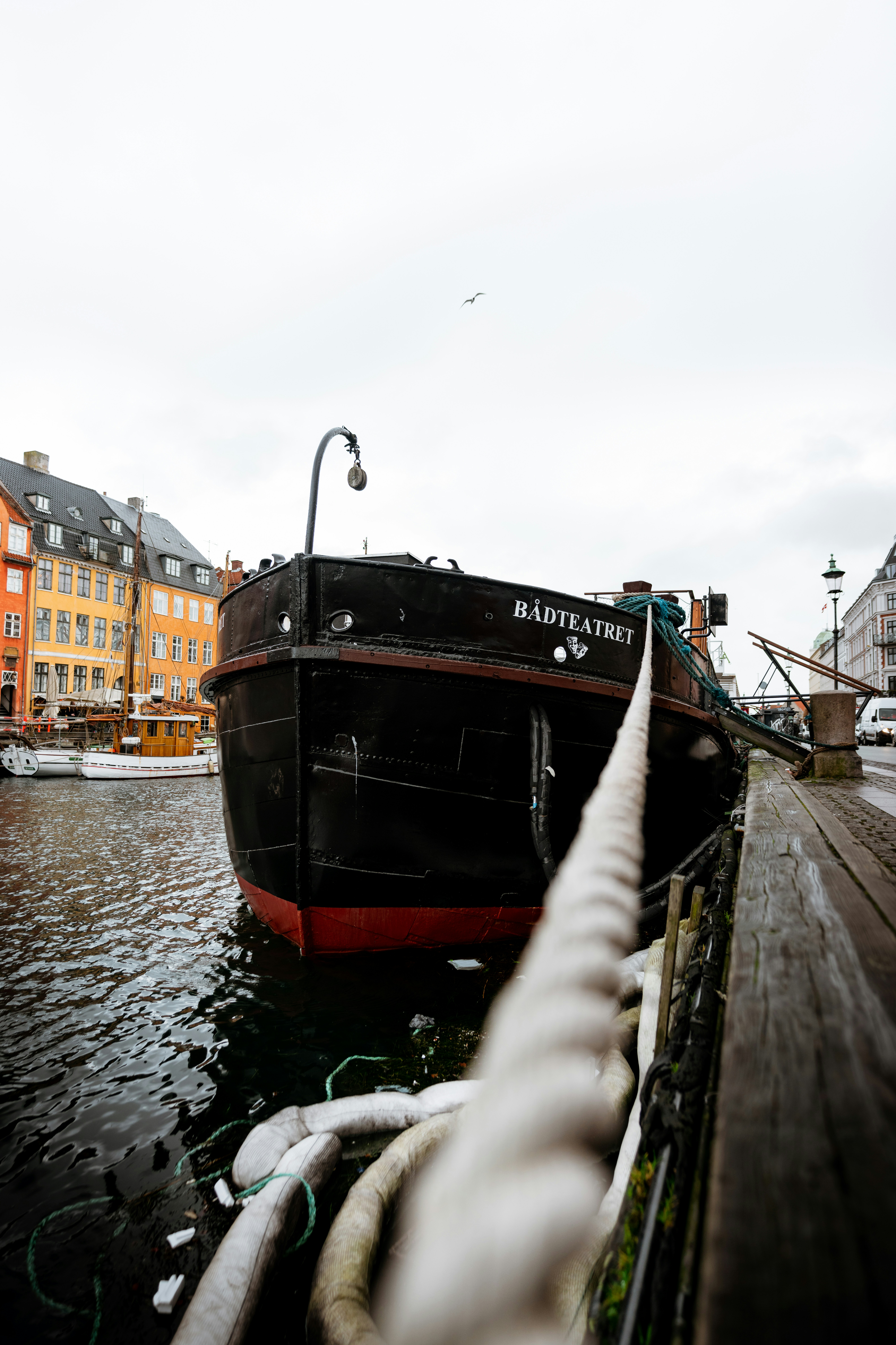 black and red boat on water near brown concrete building during daytime