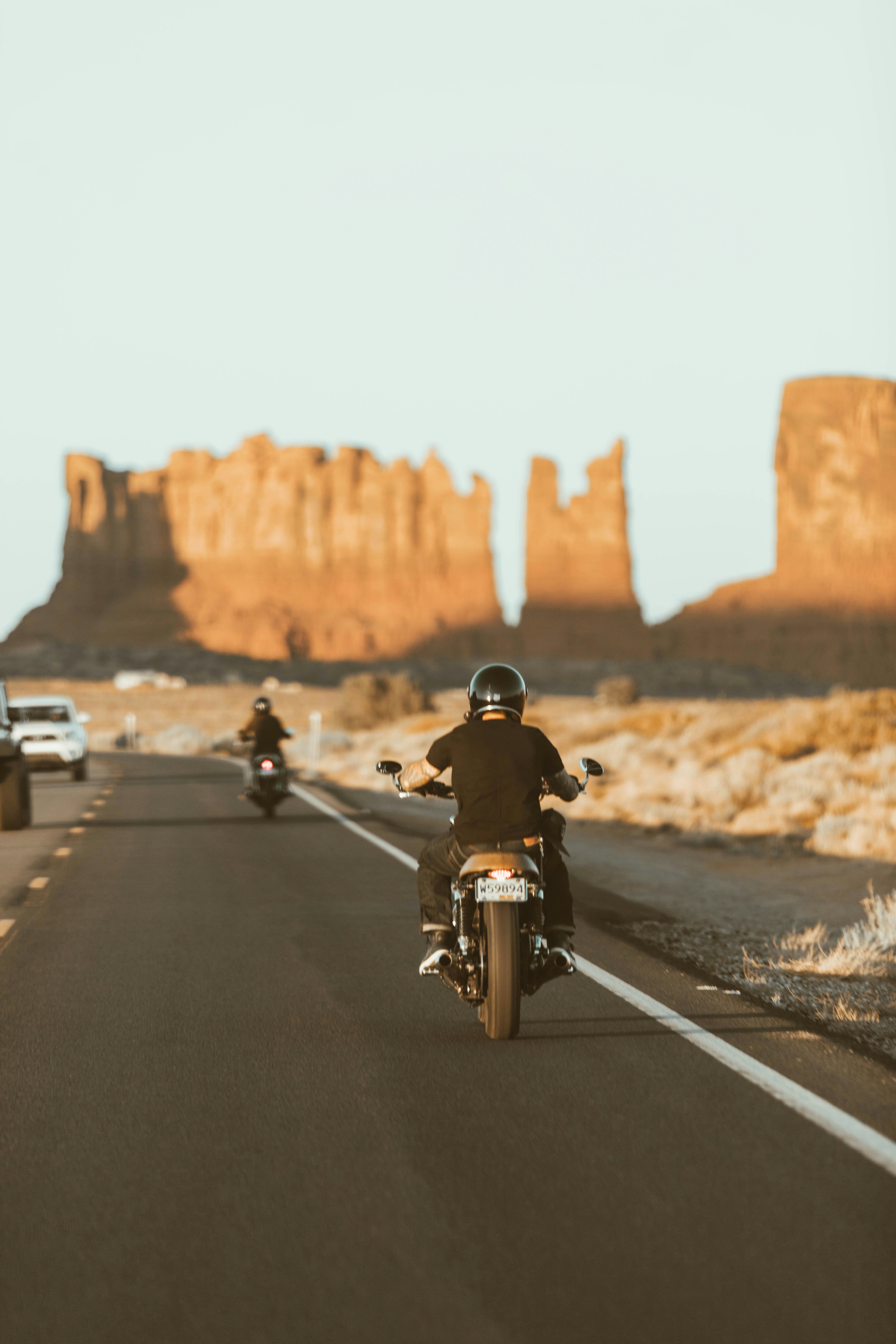Desert Highway Rider Beneath Desert Monoliths at Golden Hour