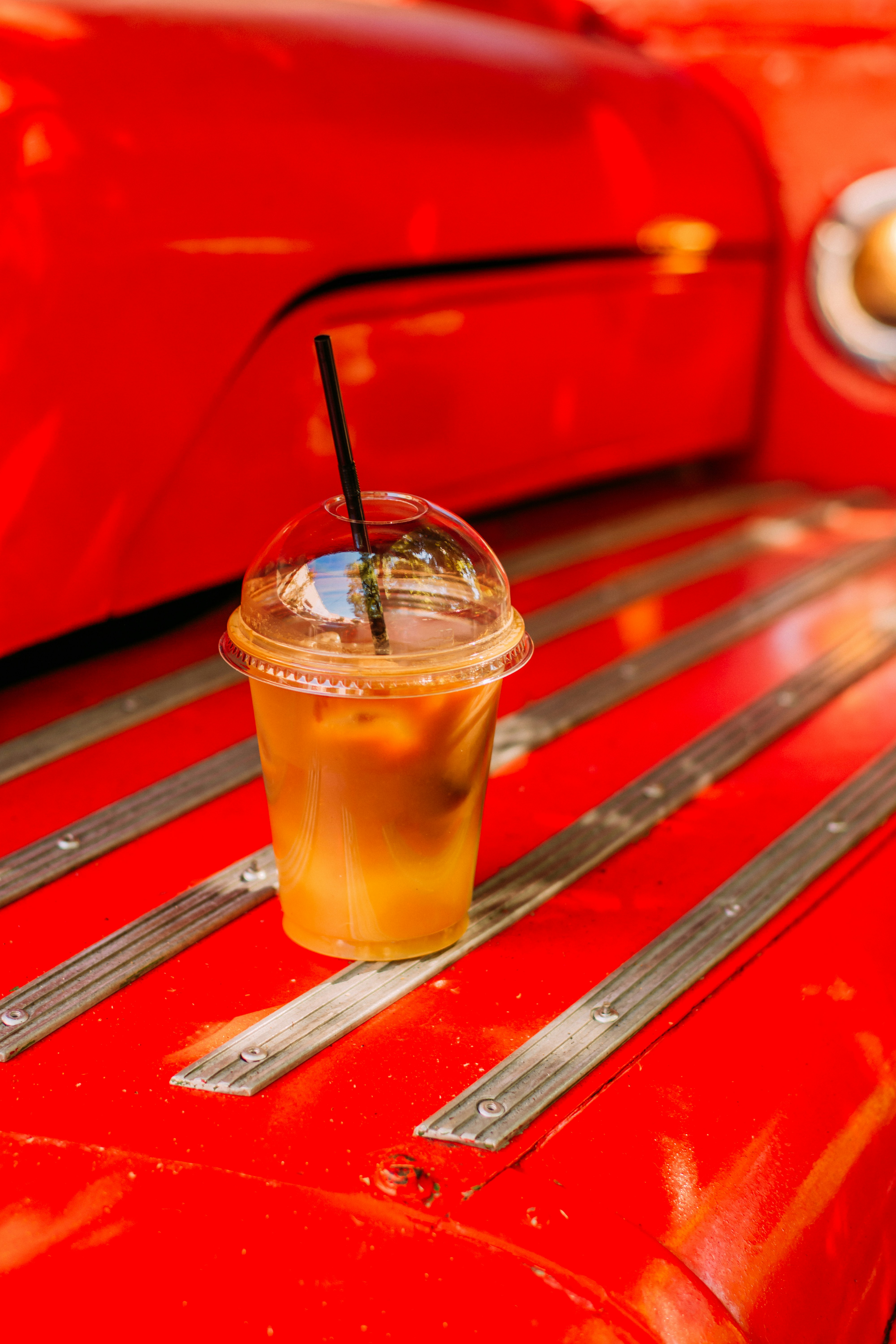 Iced Coffee on a Red Truck Bed: A Quiet Moment Between Rails