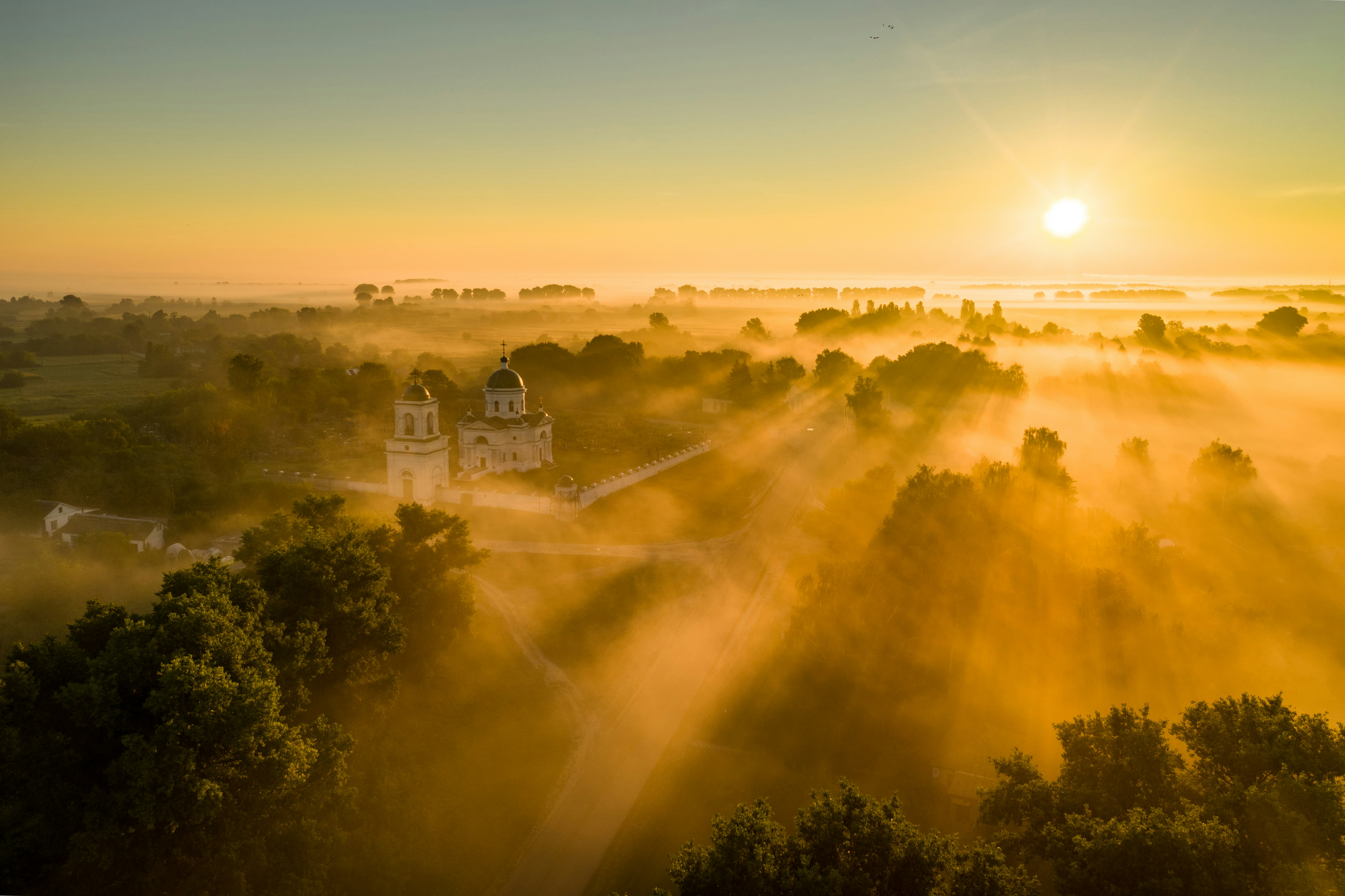 Sunrise over a tranquil hive: monastery spires emerging through golden mist