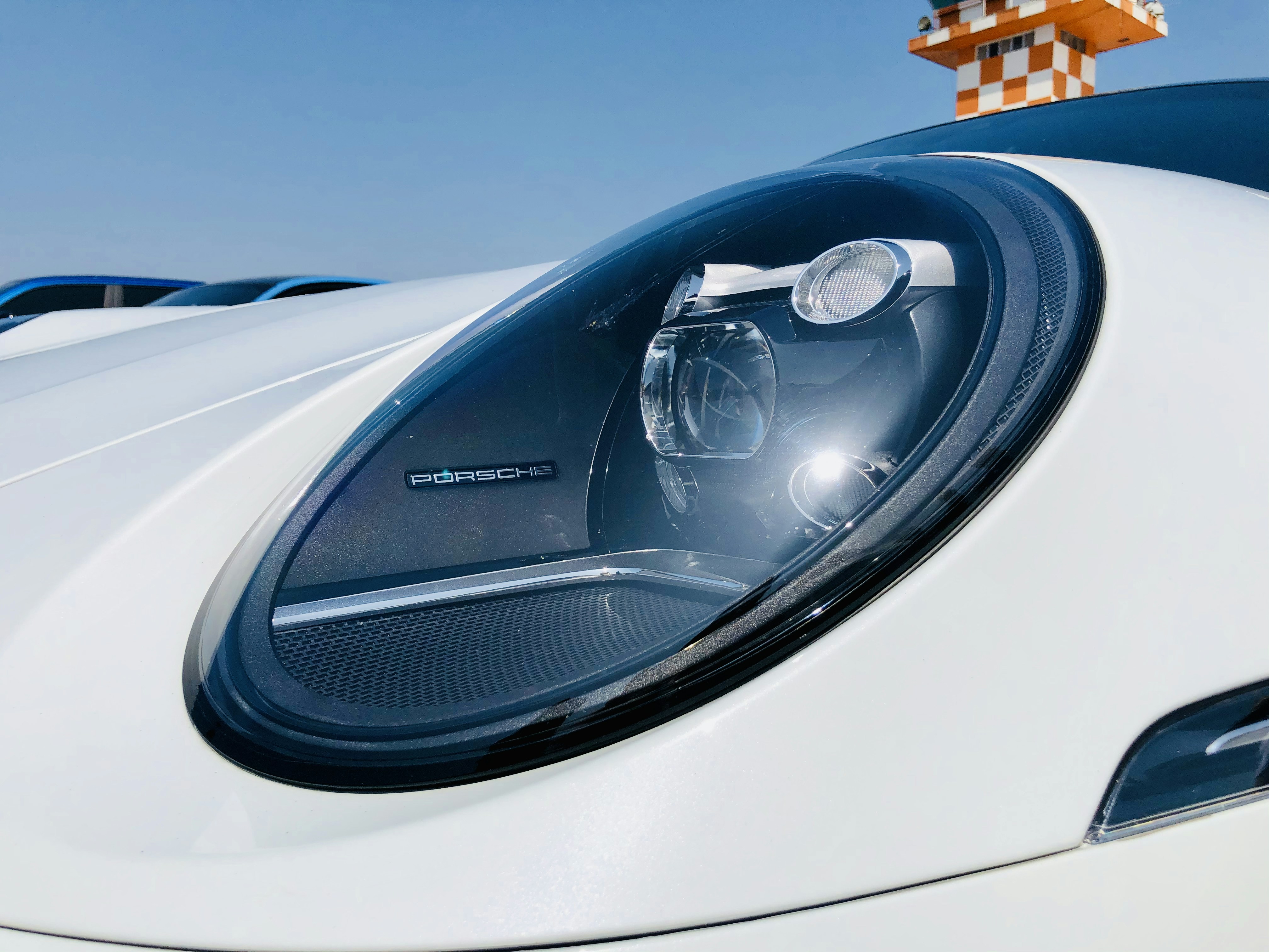 Close-up of a Porsche headlight: glass, chrome and curvature in focus