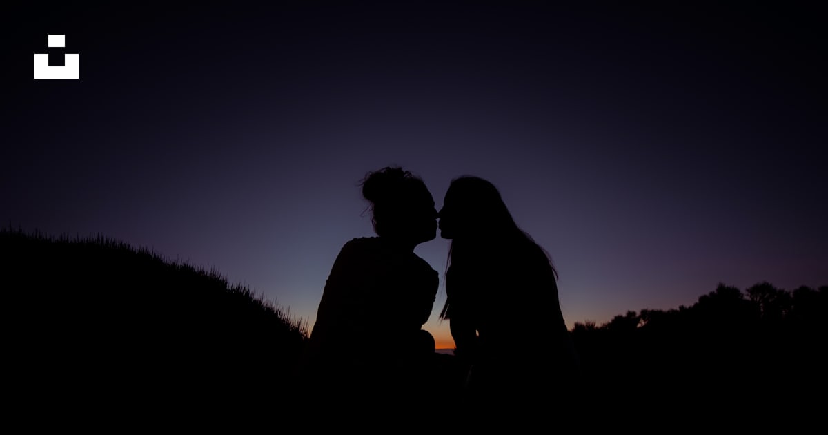 Silueta De Hombre Y Mujer Besándose Durante La Puesta Del Sol Foto