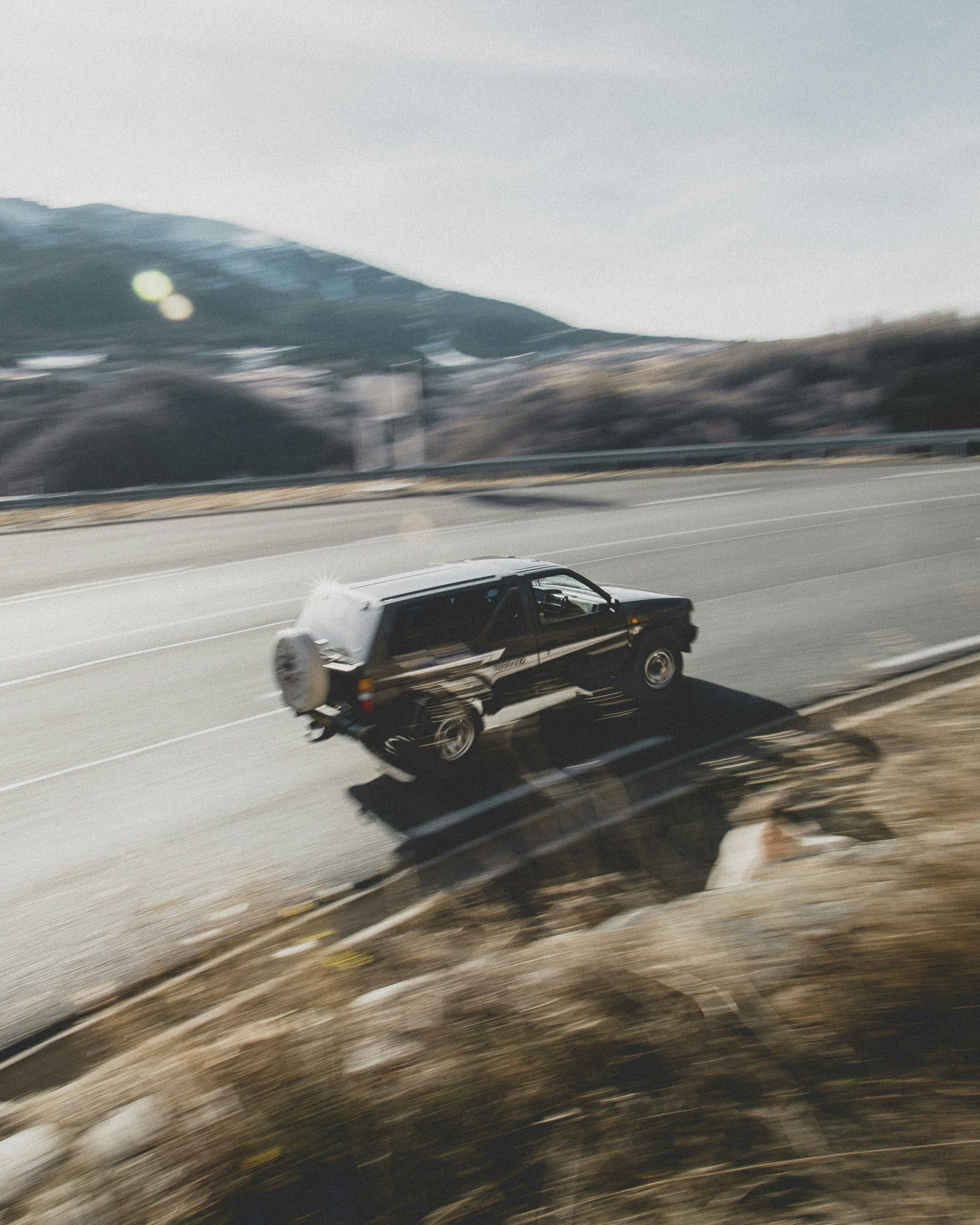 Momentum on the Curve: A rugged SUV carves through a sunlit mountain pass.