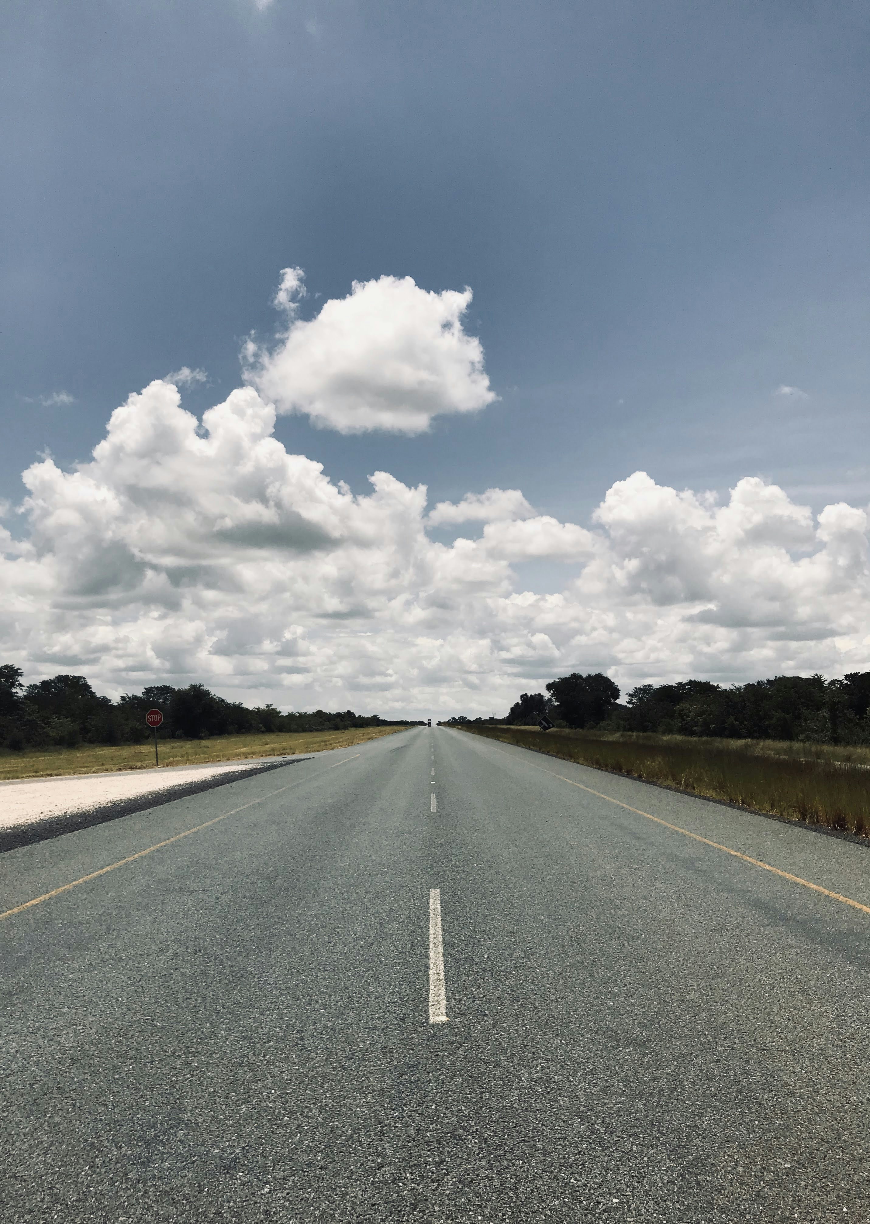 Endless Highway Under a Sky of Puffy Clouds