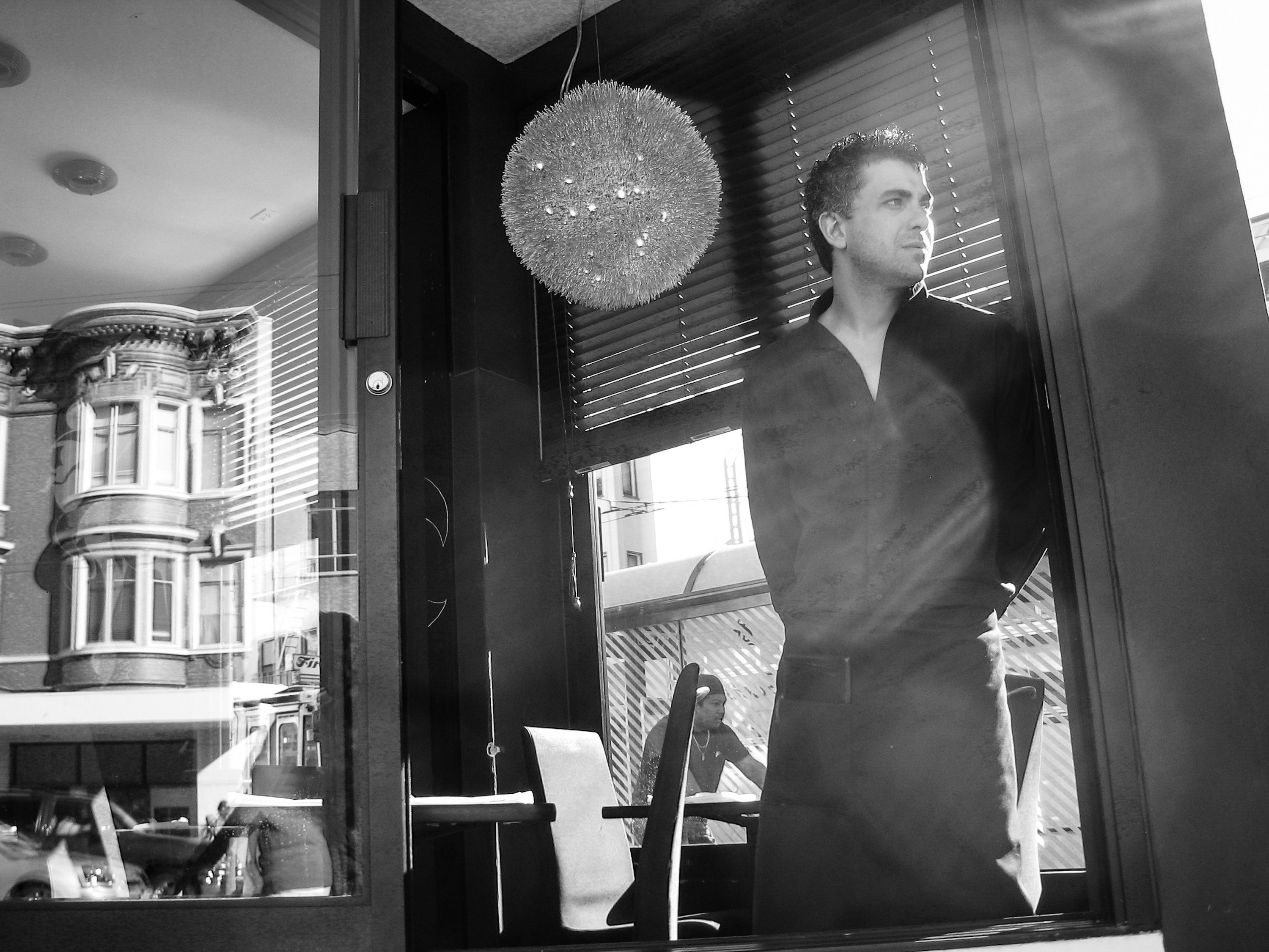 Threshold Portrait: A Man in a Quiet Café Window