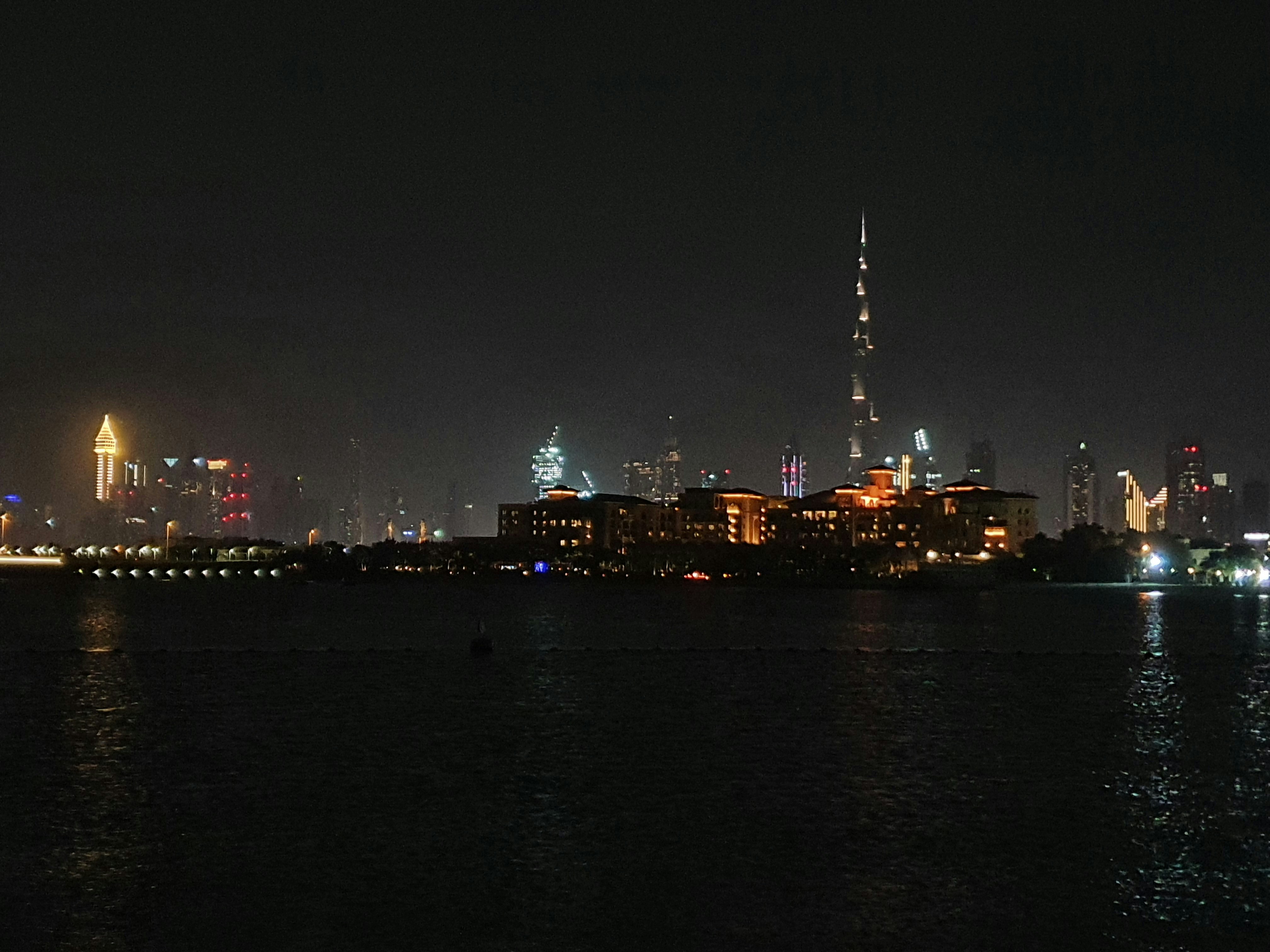 Neon Outlines: Nighttime Skyline Across Still Water