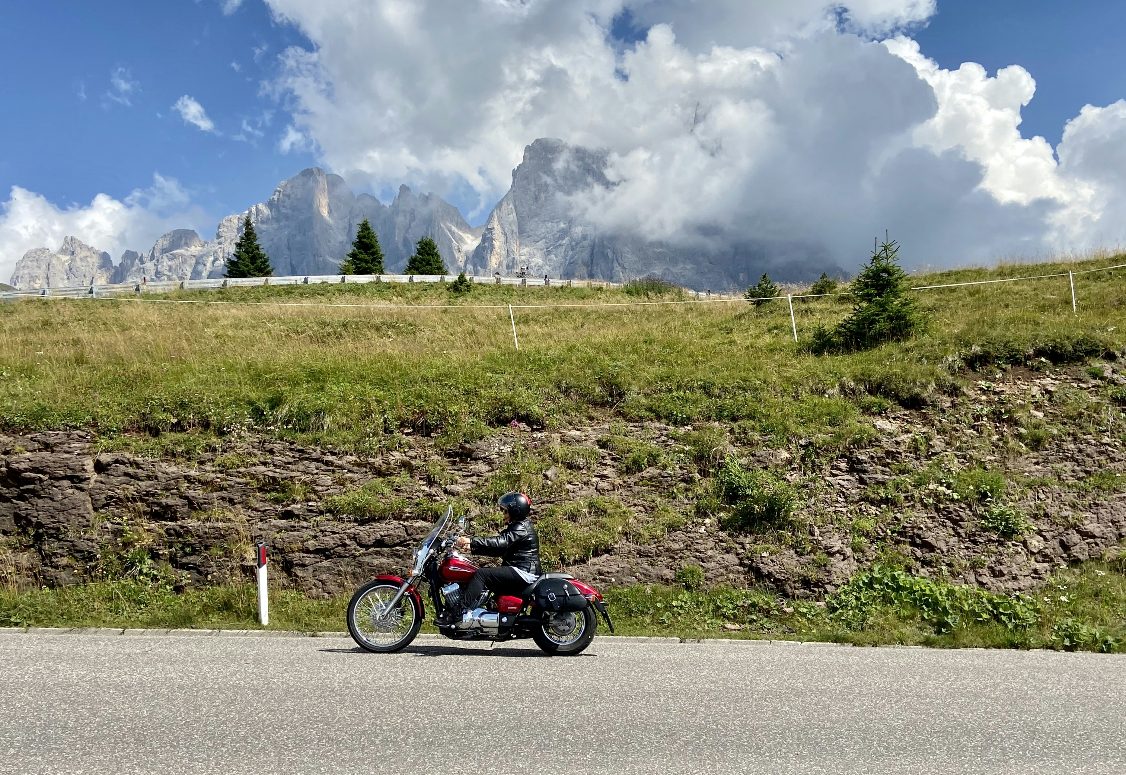 Steely Rider on a Dolomites Pass Beneath Cloud-sculpted Peaks