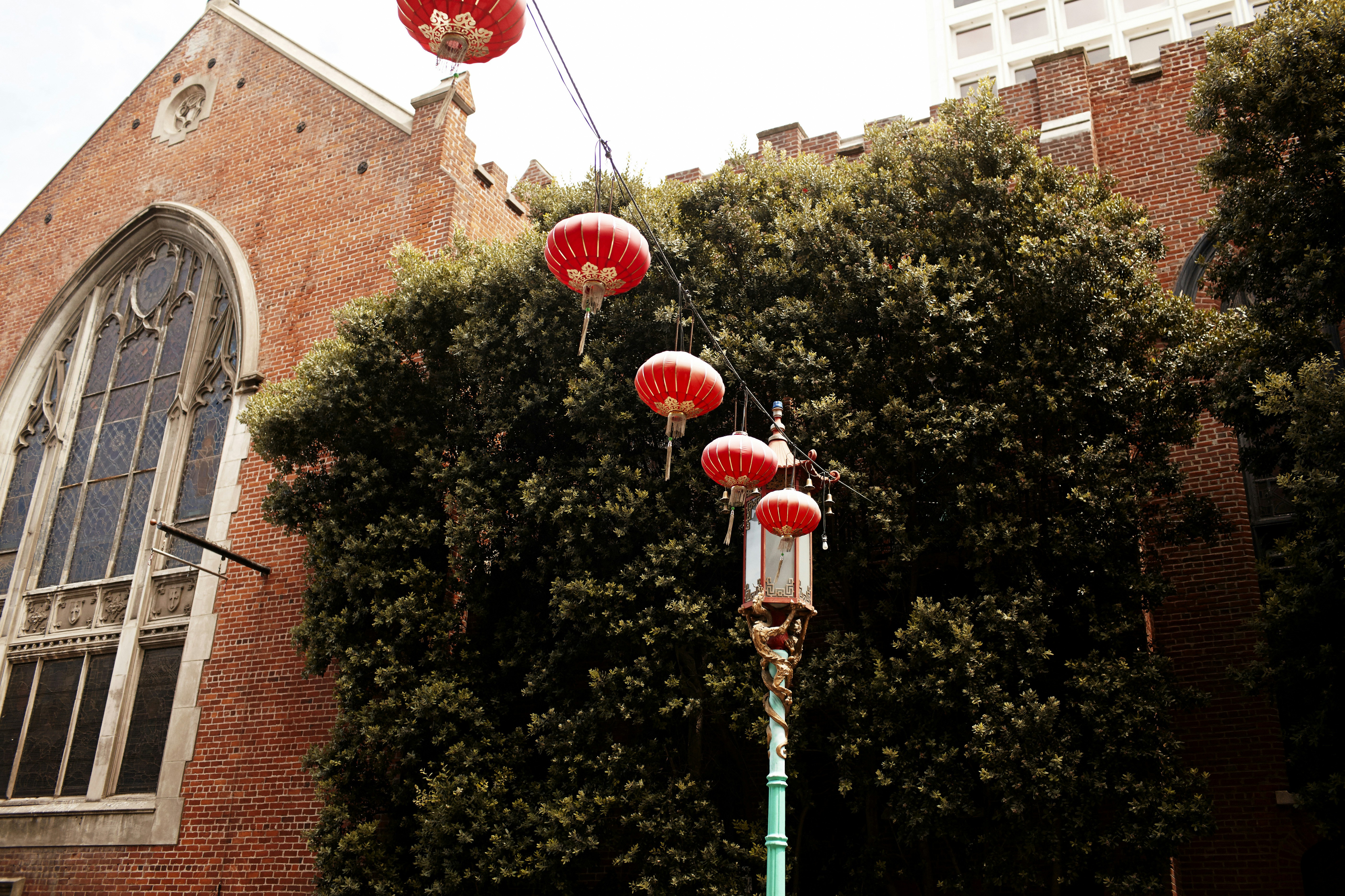 Lanterns Across the Churchyard: A Brick Facade Under Red Orbs