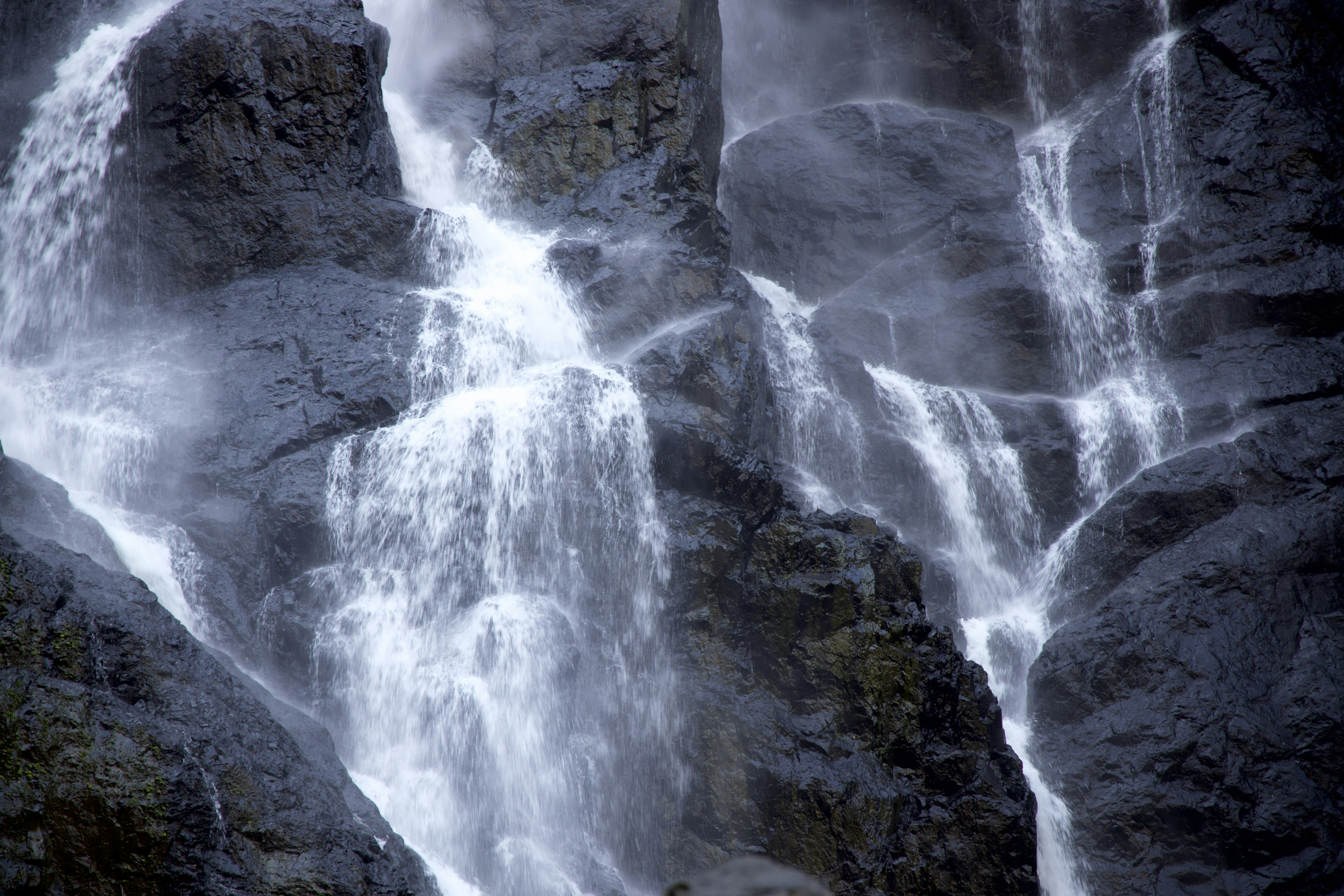 Basalt Veil: Silk Cascade Through Dim Cliffs