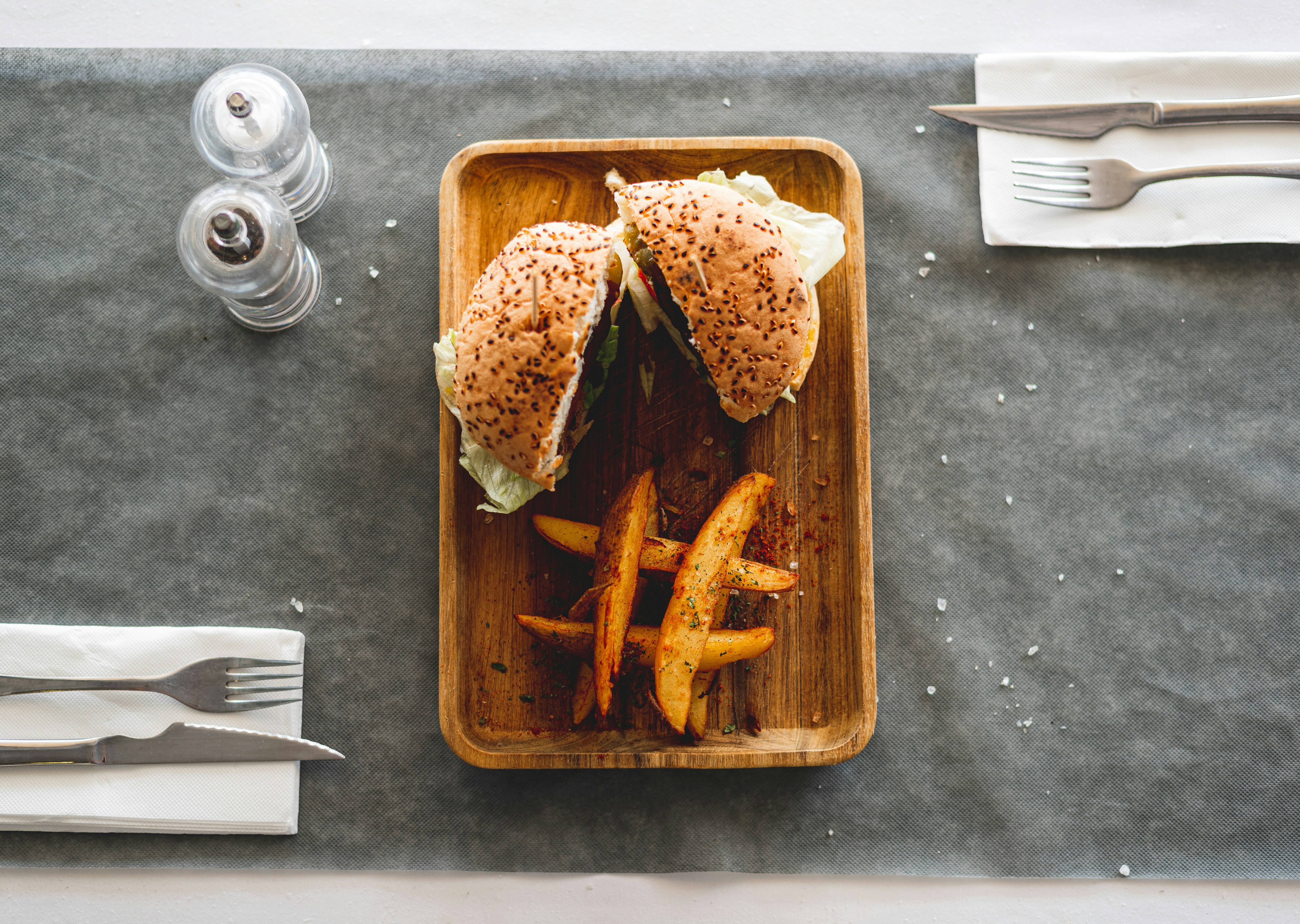 Sesame Bun Sandwich with Sea-Salted Fries on a Rustic Wooden Tray