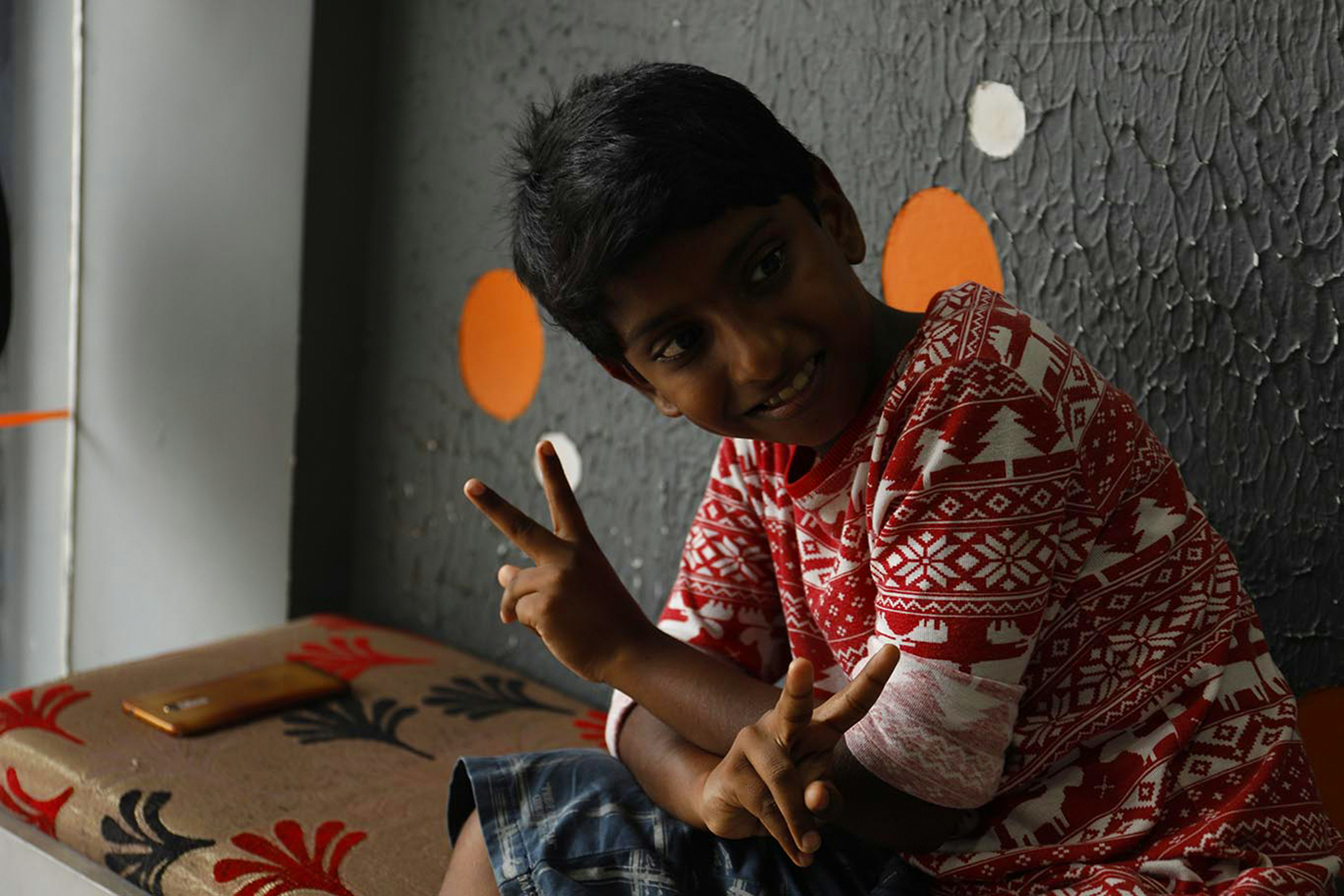 Shravan Binosh, Kerala,Kottayam, India | woman in red and white floral shirt sitting on bed