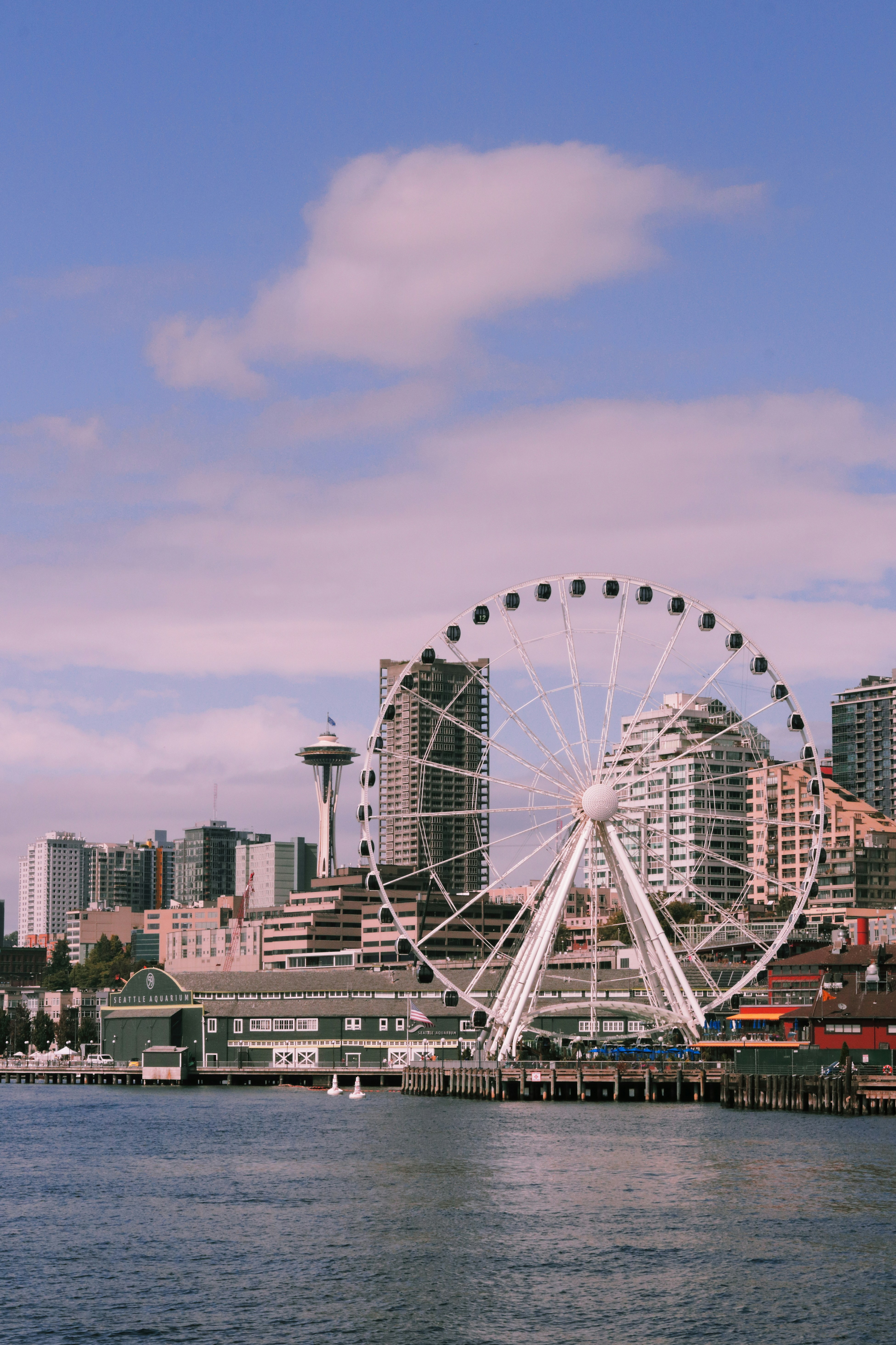 Ferris wheel near city buildings under blue sky during daytime photo ...