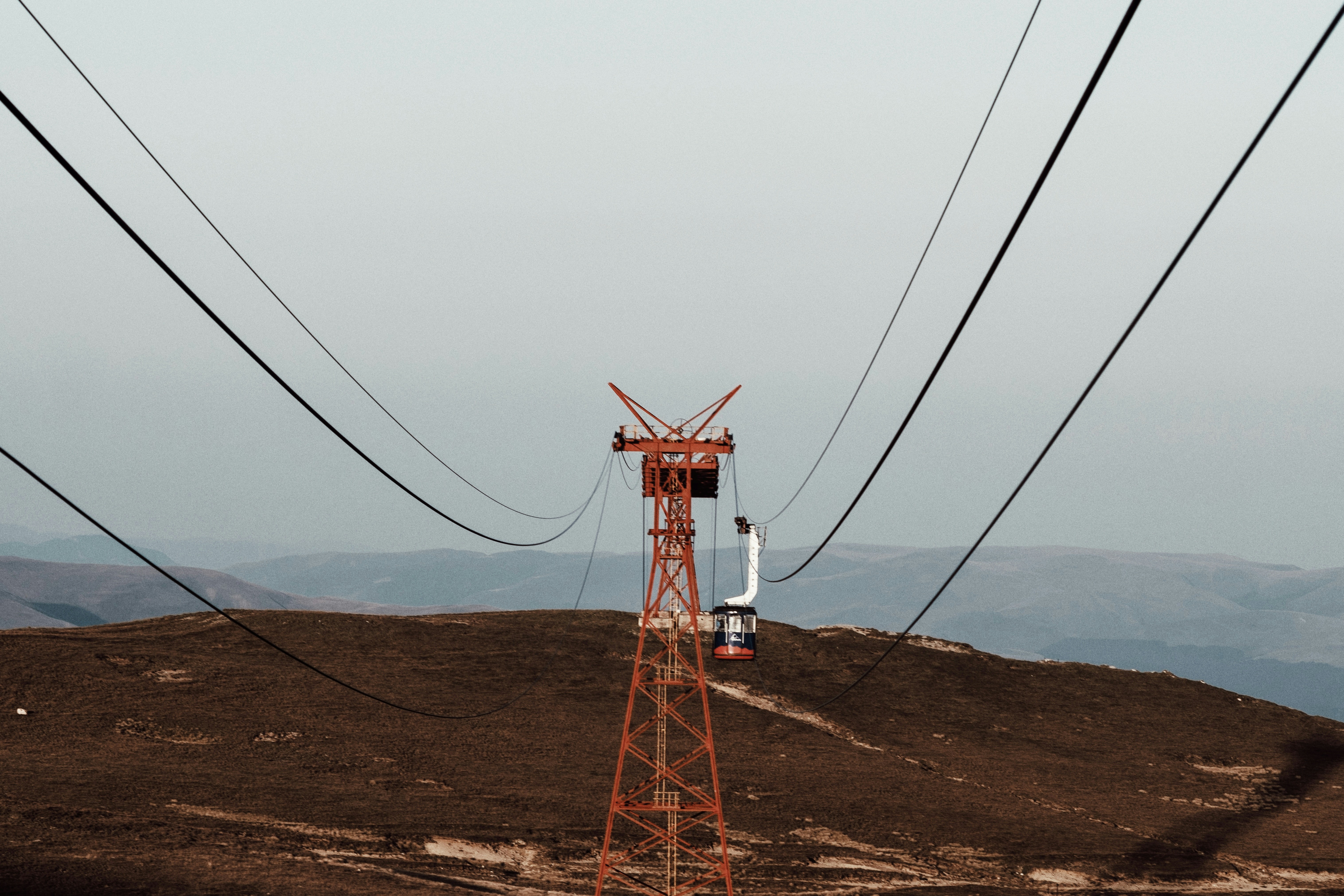 Red lattice tower and the spiderweb of cables over a desolate moor