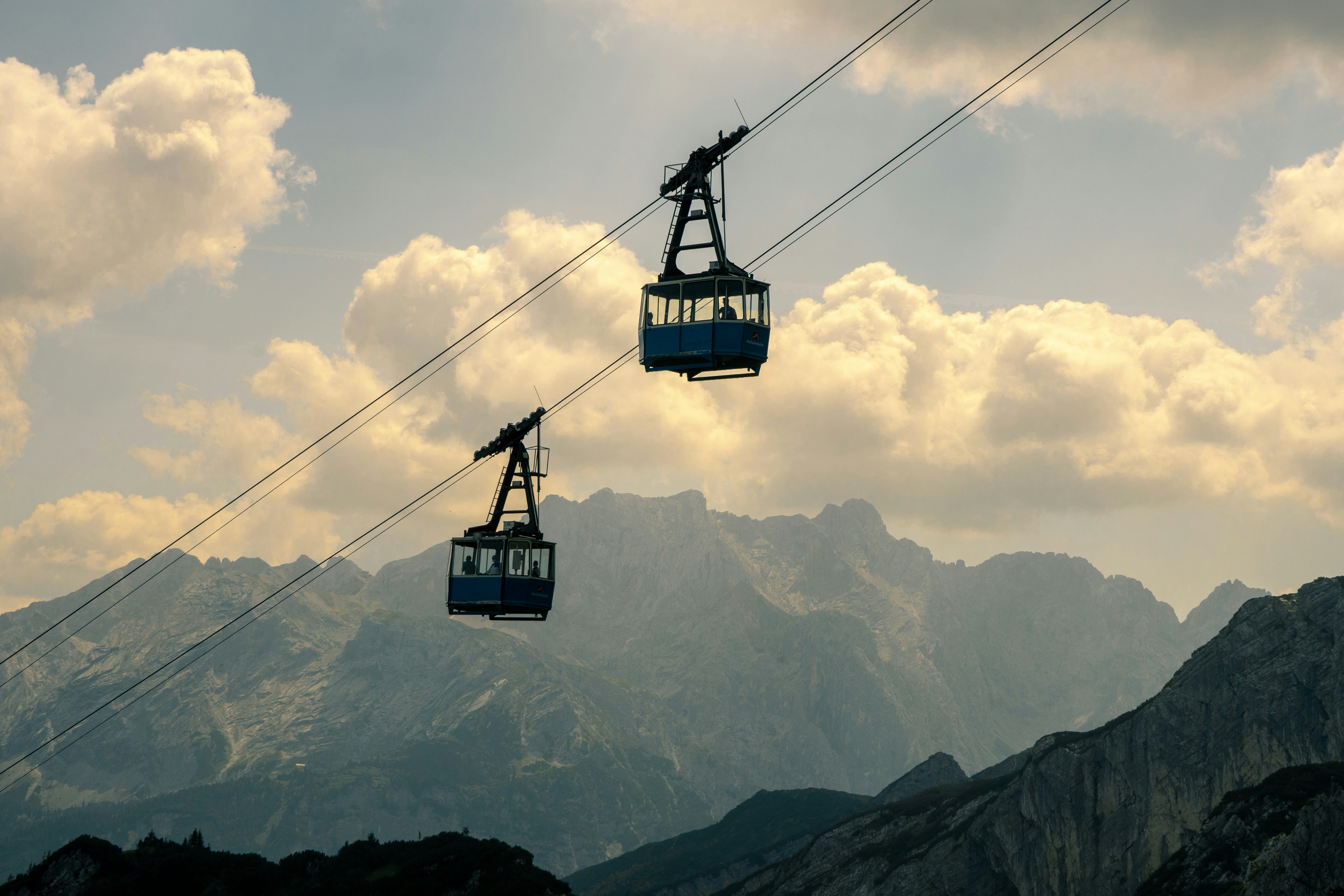 Cable Cars Over Jagged Dolomites Against a Misty Alpine Sky