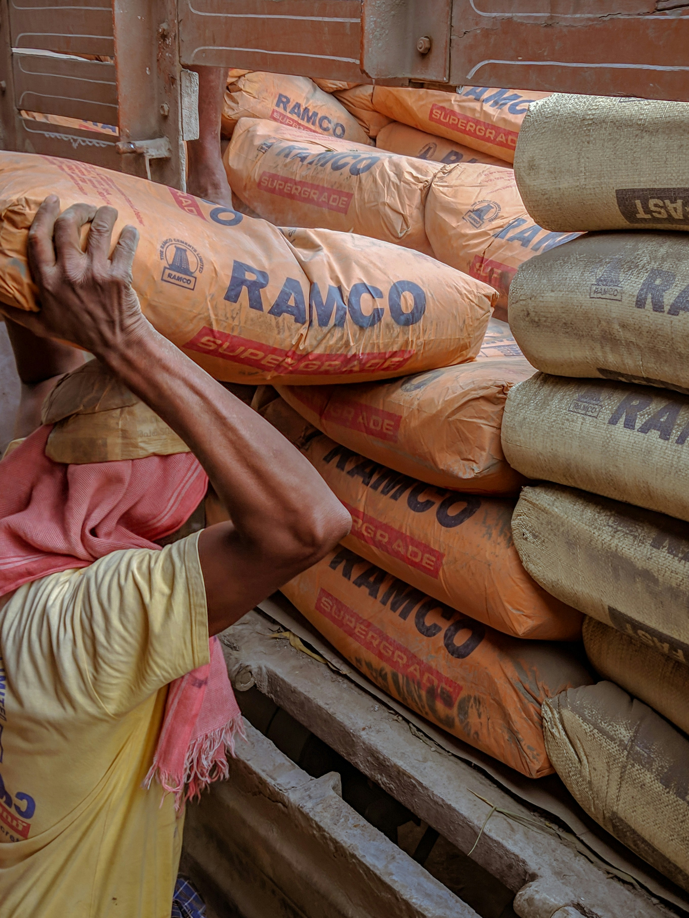 Man in pink t-shirt and brown pants sitting on brown wooden bench photo ...