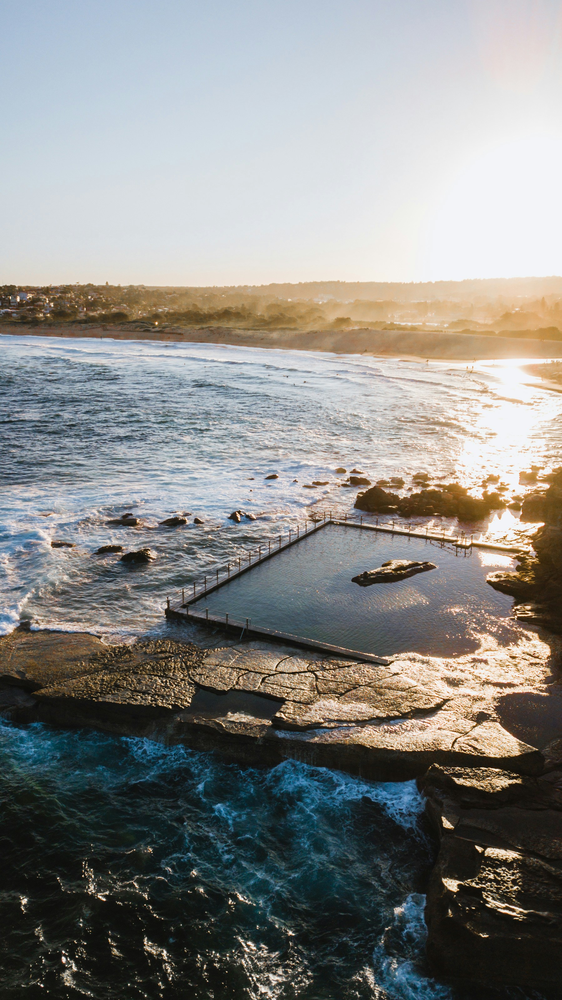 Sunlit Ocean Pool Overlooking a Rocky Shoreline