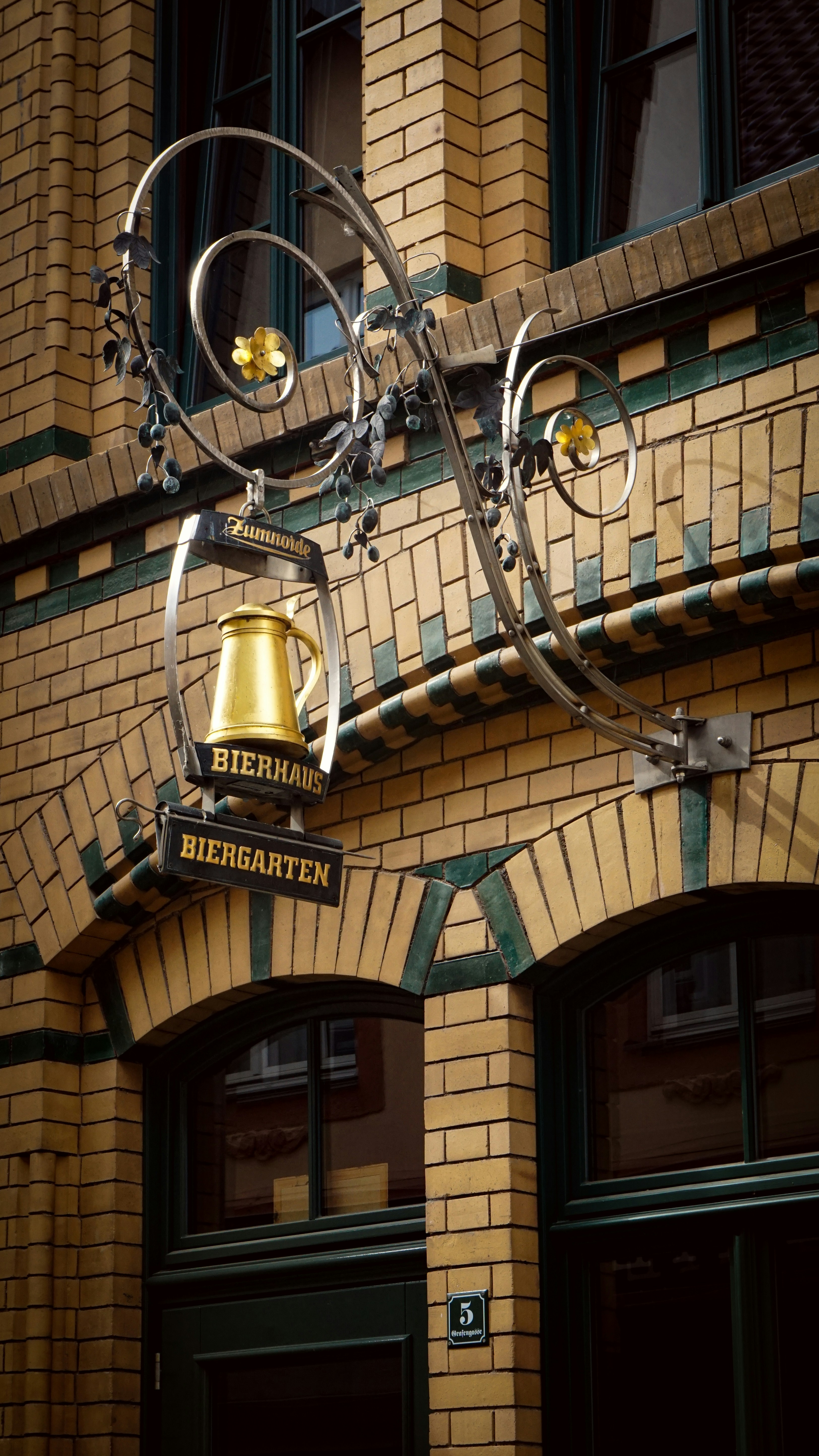 Copper Lantern Signage Adorning a Historic Brick Facade