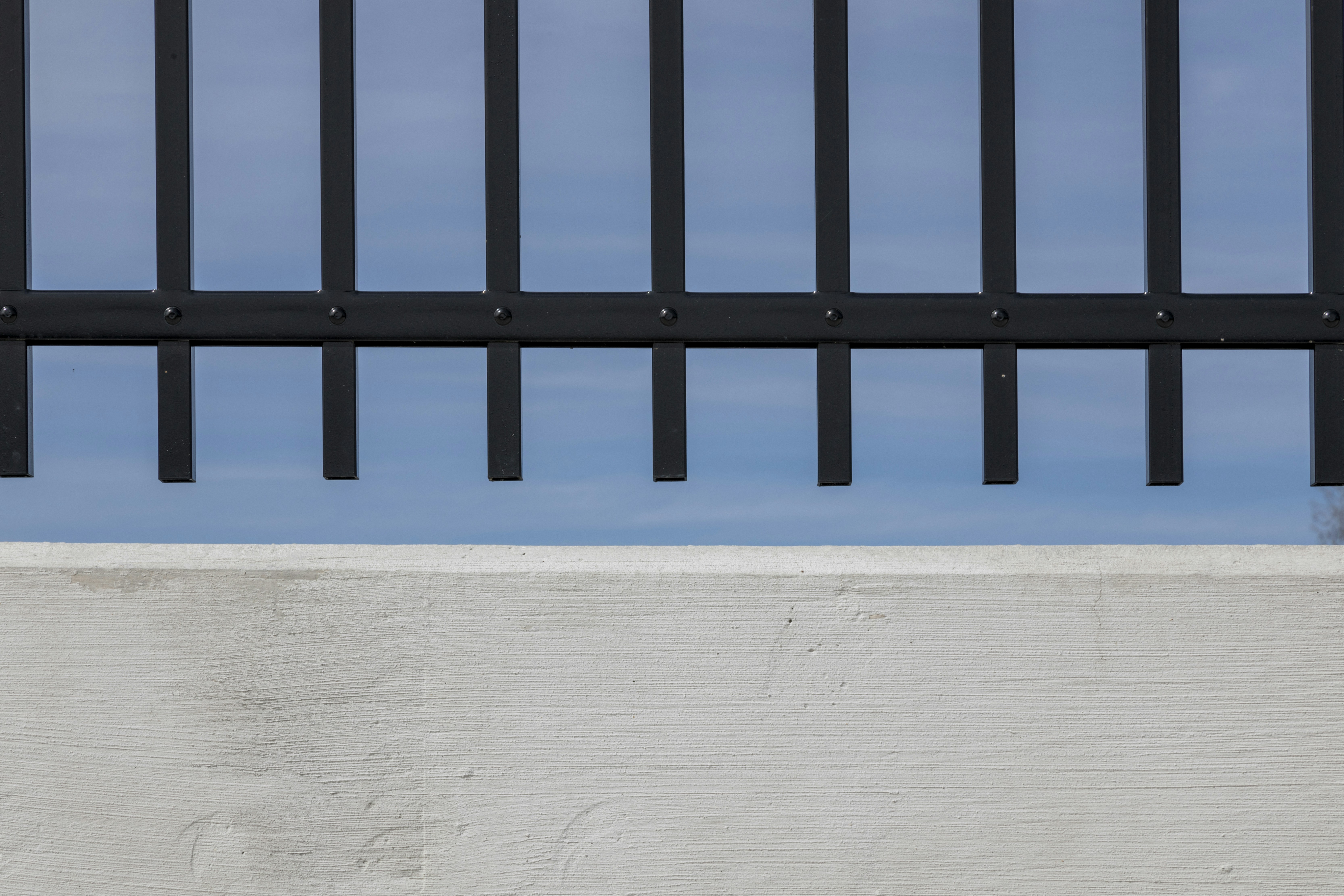 Black and Blue and White Bridge | black metal fence on white wall