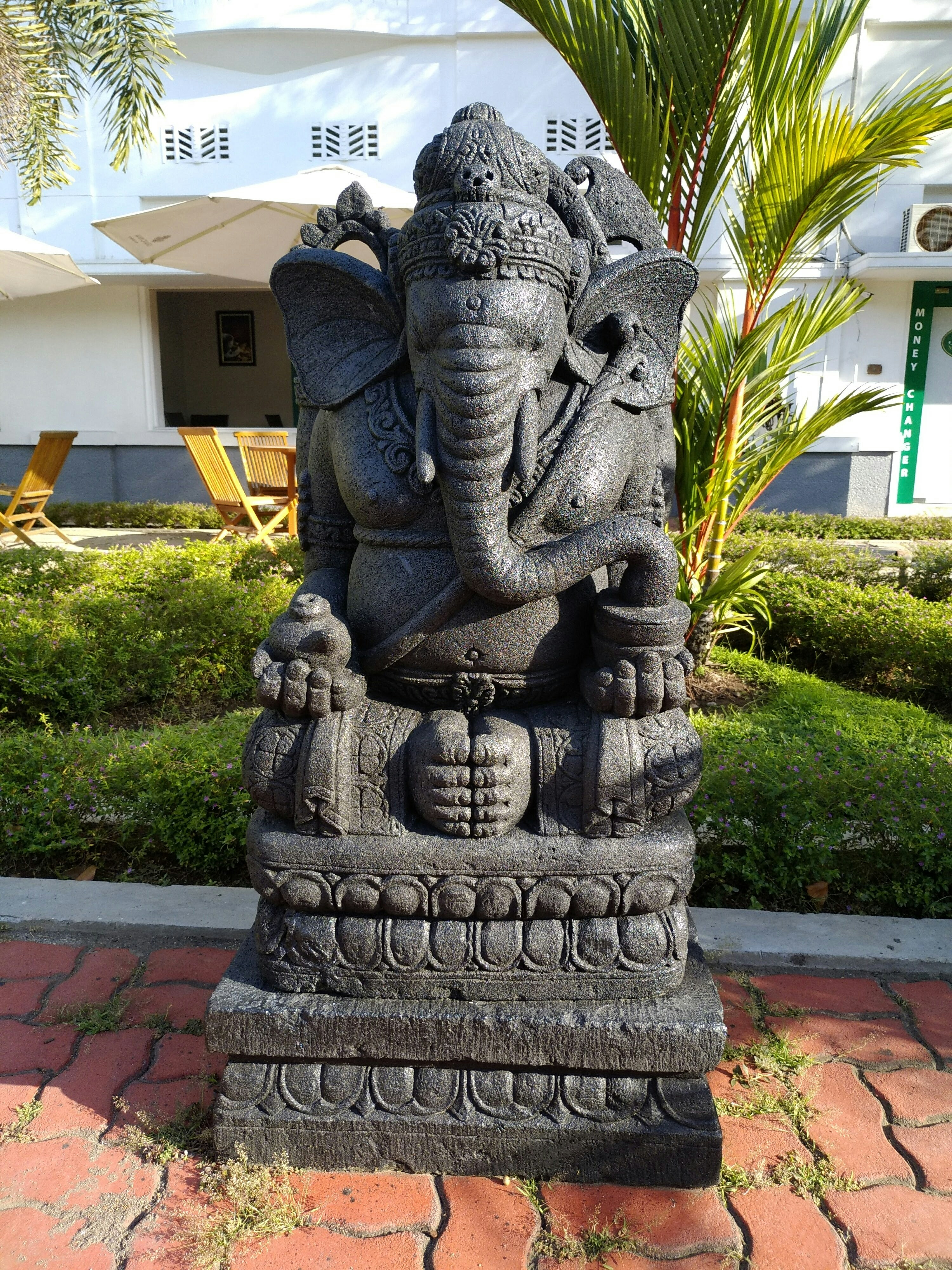 Courtyard Ganesha: Weathered Granite Guardian in Sunlit Tranquility