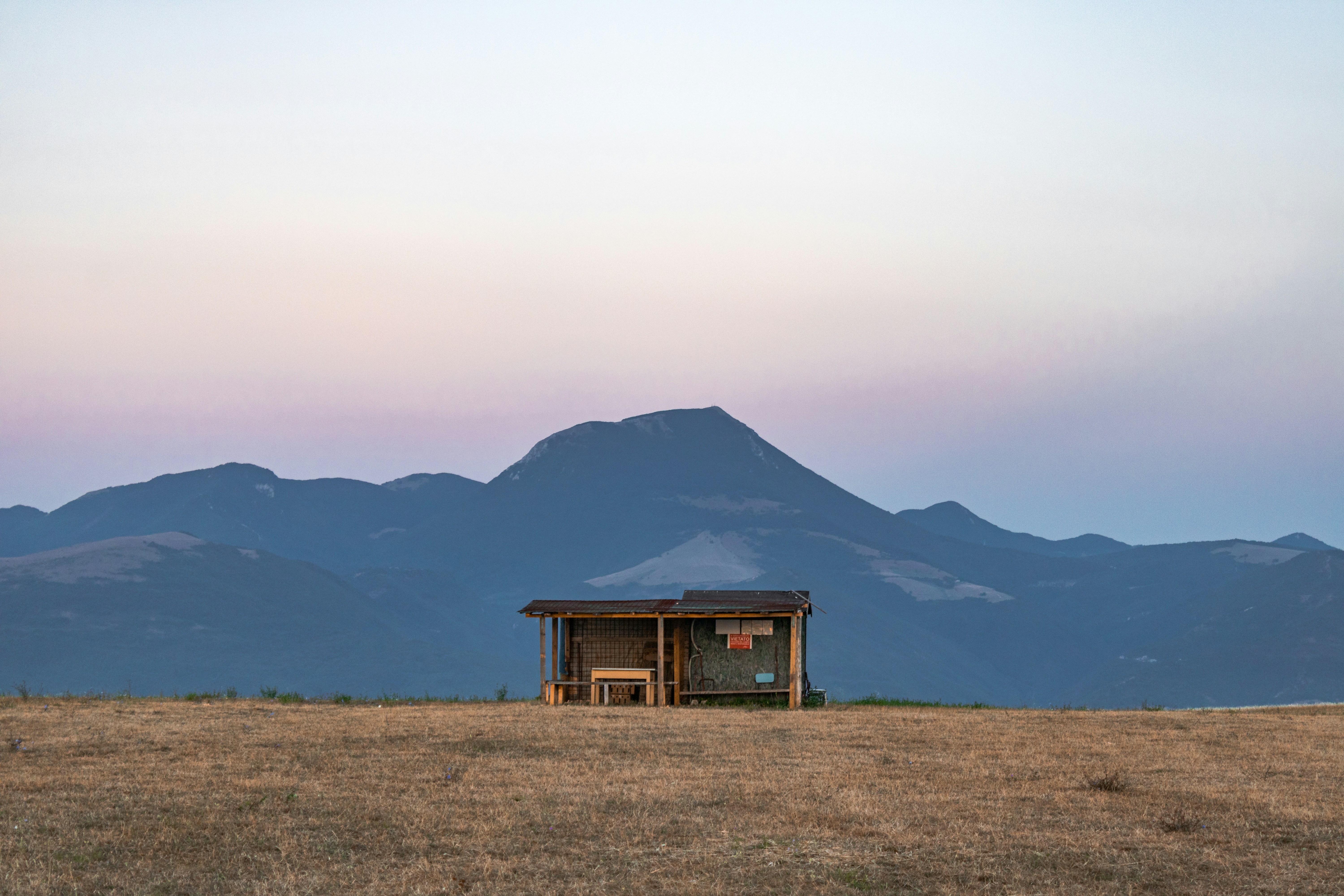 Deserted Shelter Beneath a Quiet Mountain Range at Dusk