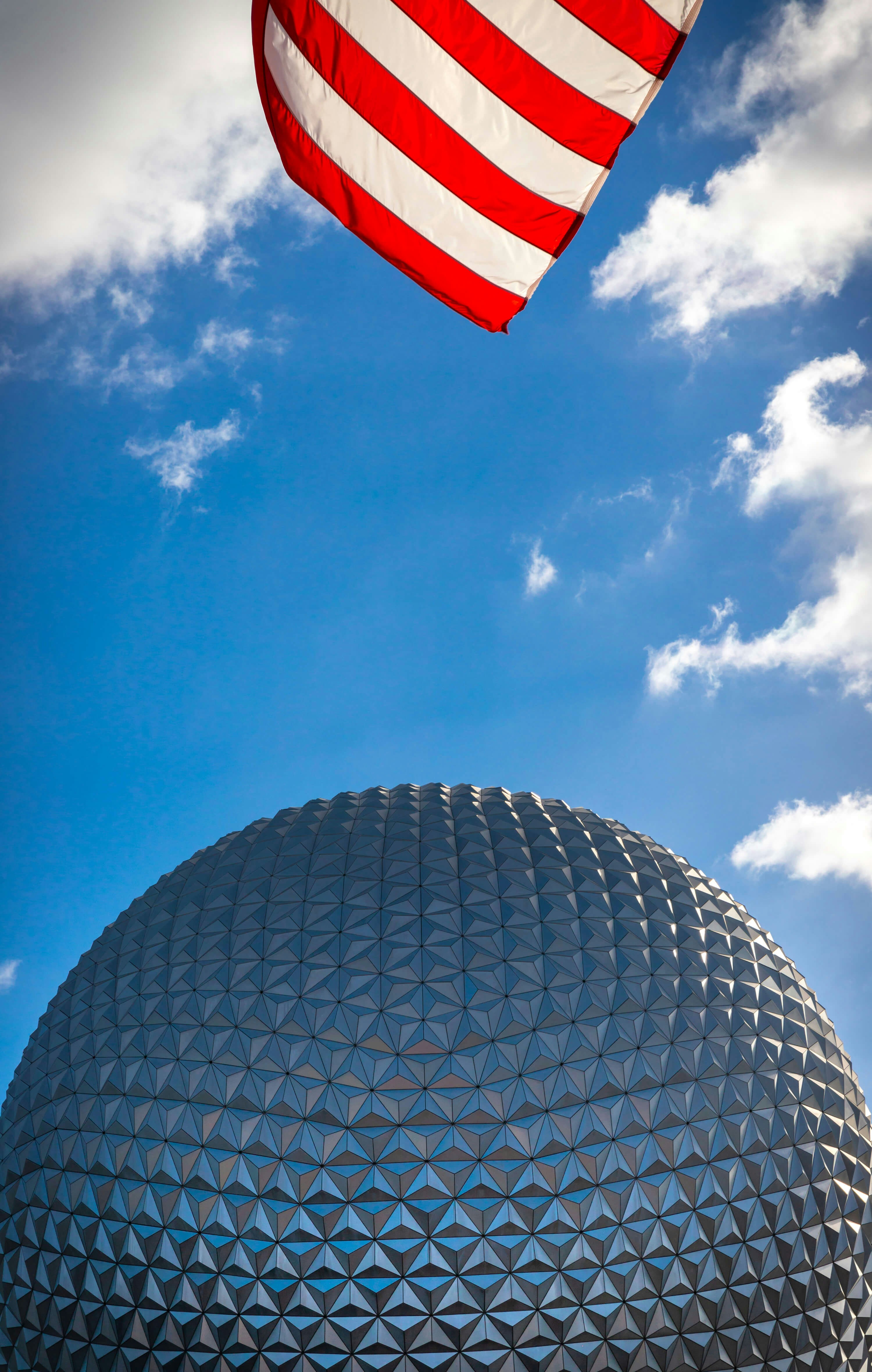 American Flag Arcing Above the Geometric Dome Against a Bright Sky