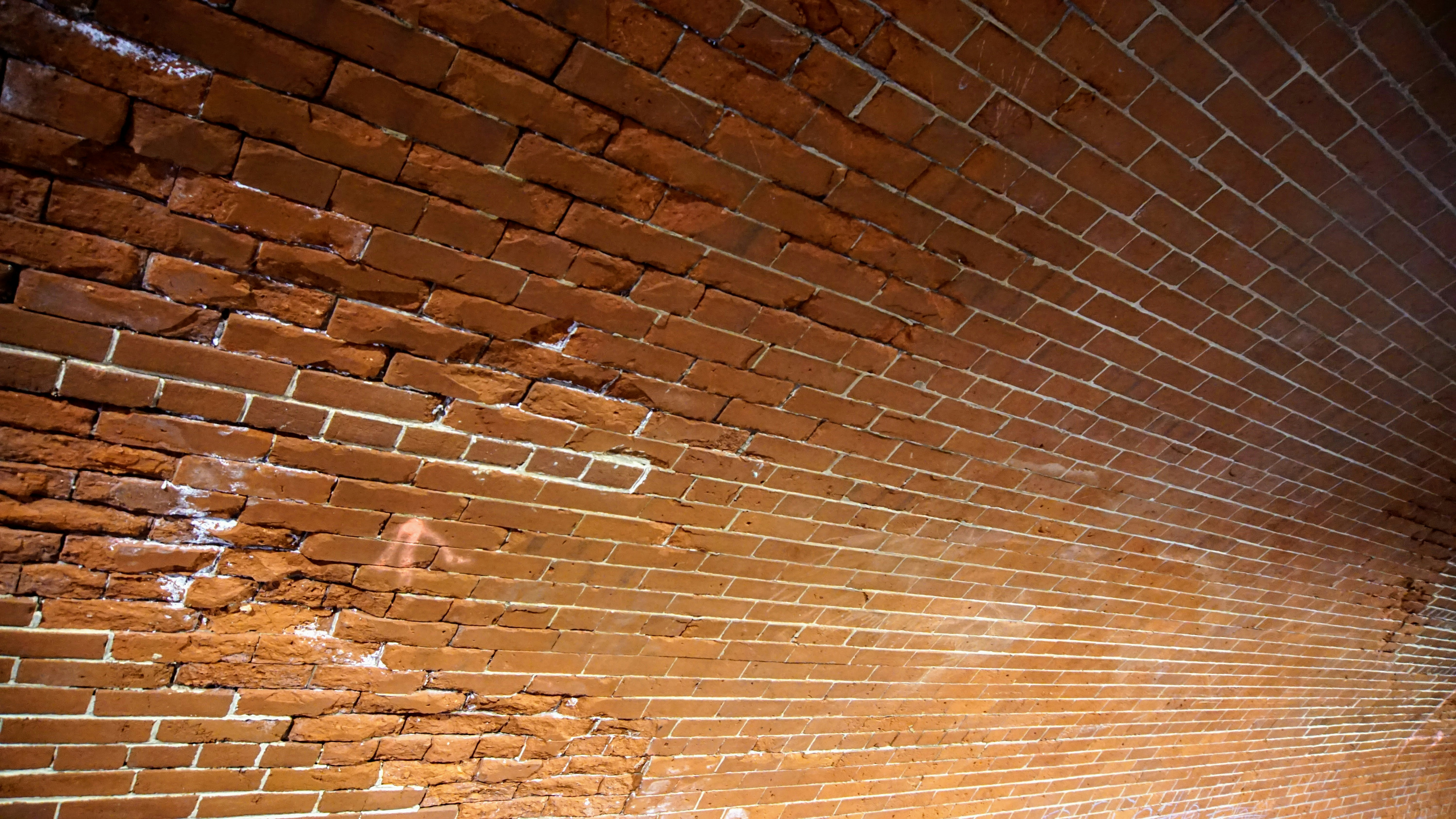 Glow Along a Brick Vault: A Low-Angle Portrait of Warm Light Across Brickwork