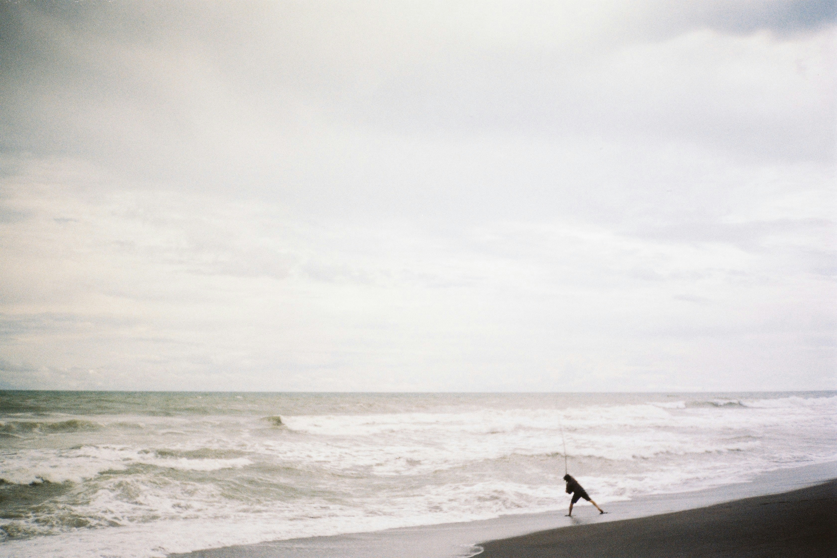 Personne tenant une planche de surf marchant sur la plage pendant la ...