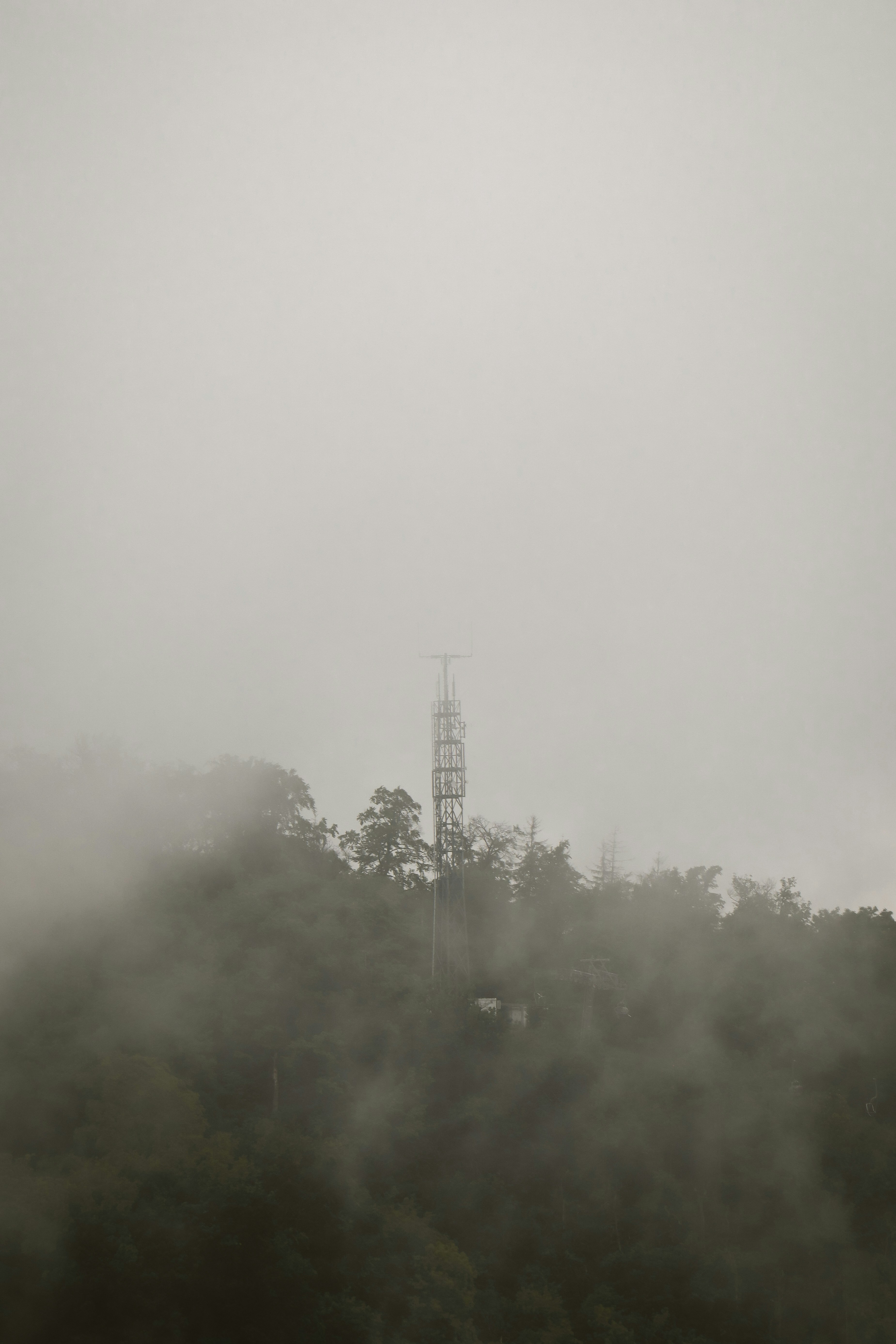 A tower thing on top of a mountain on a cloudy day