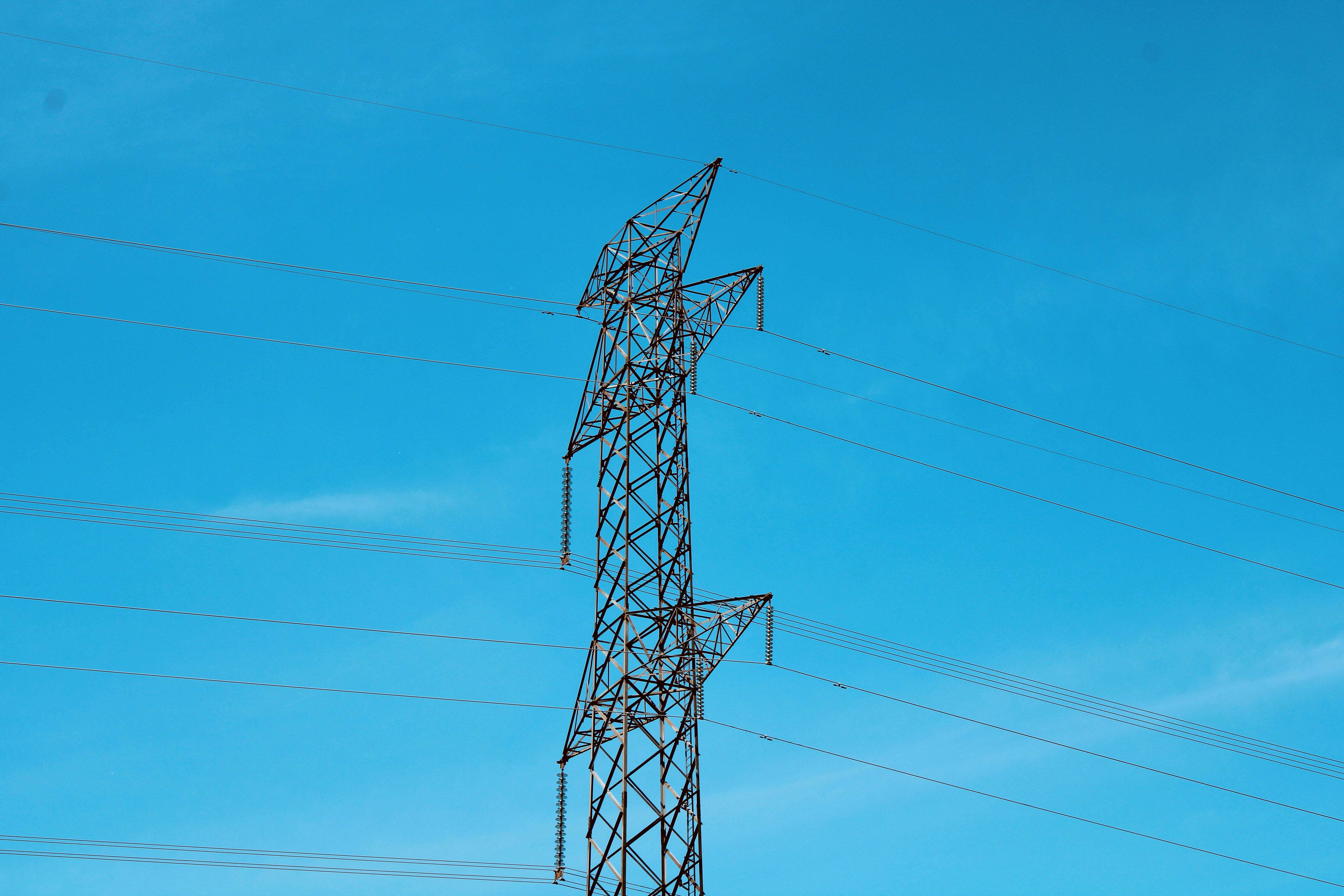 black electric post under blue sky during daytime