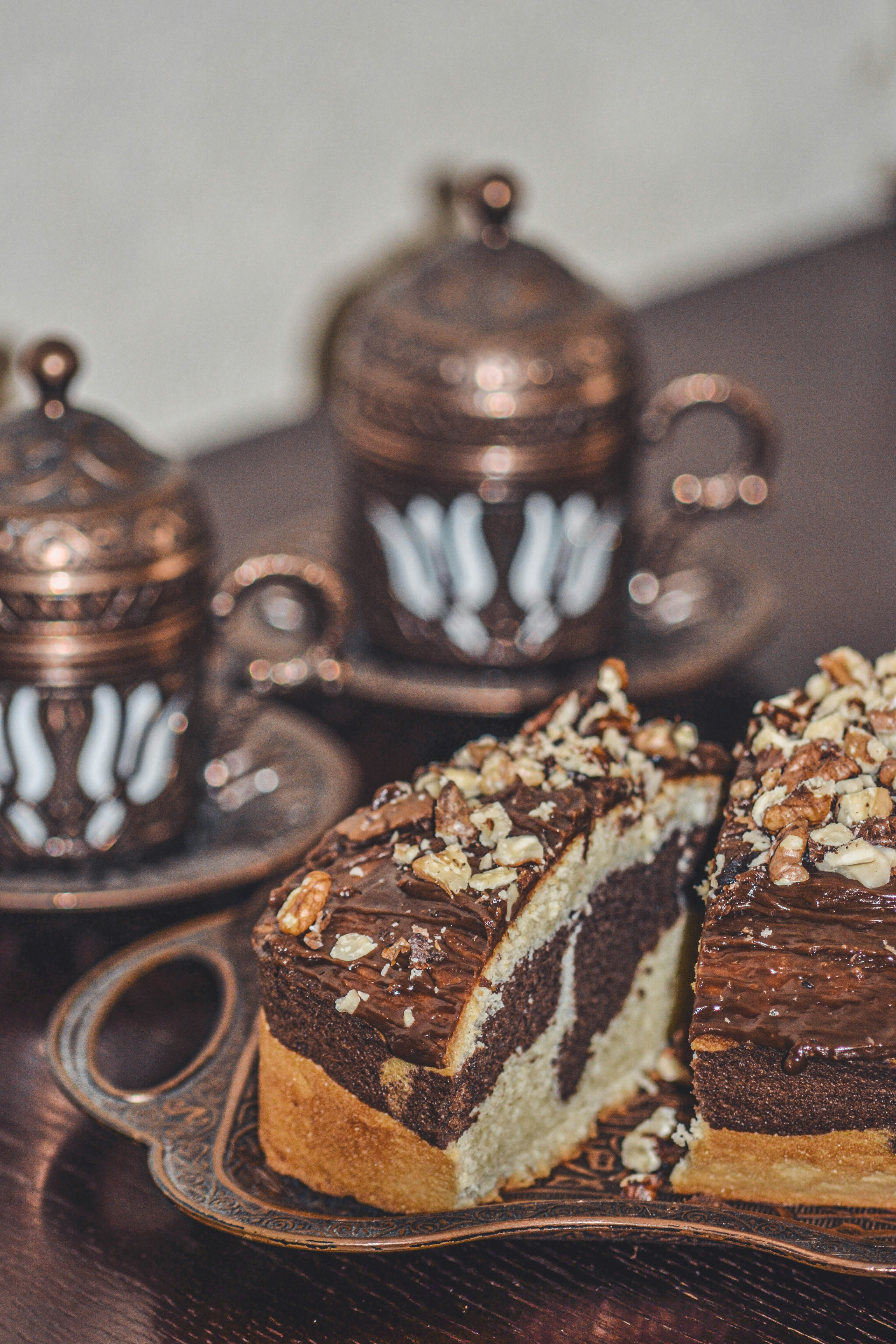 Nut-Crowned Chocolate Layer Cake on a Copper-Themed Table
